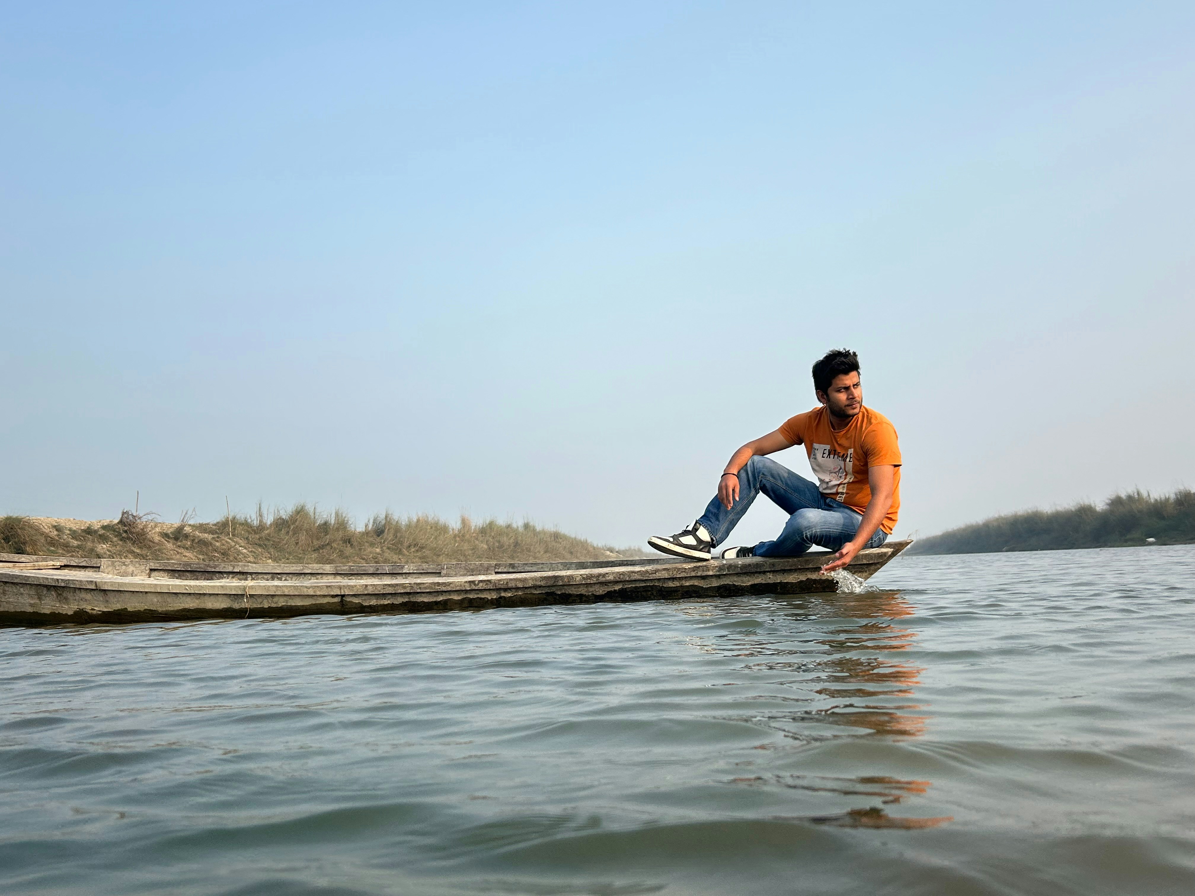 Orange Shirt on a Weathered Dock: a Quiet Portrait over Calm Water