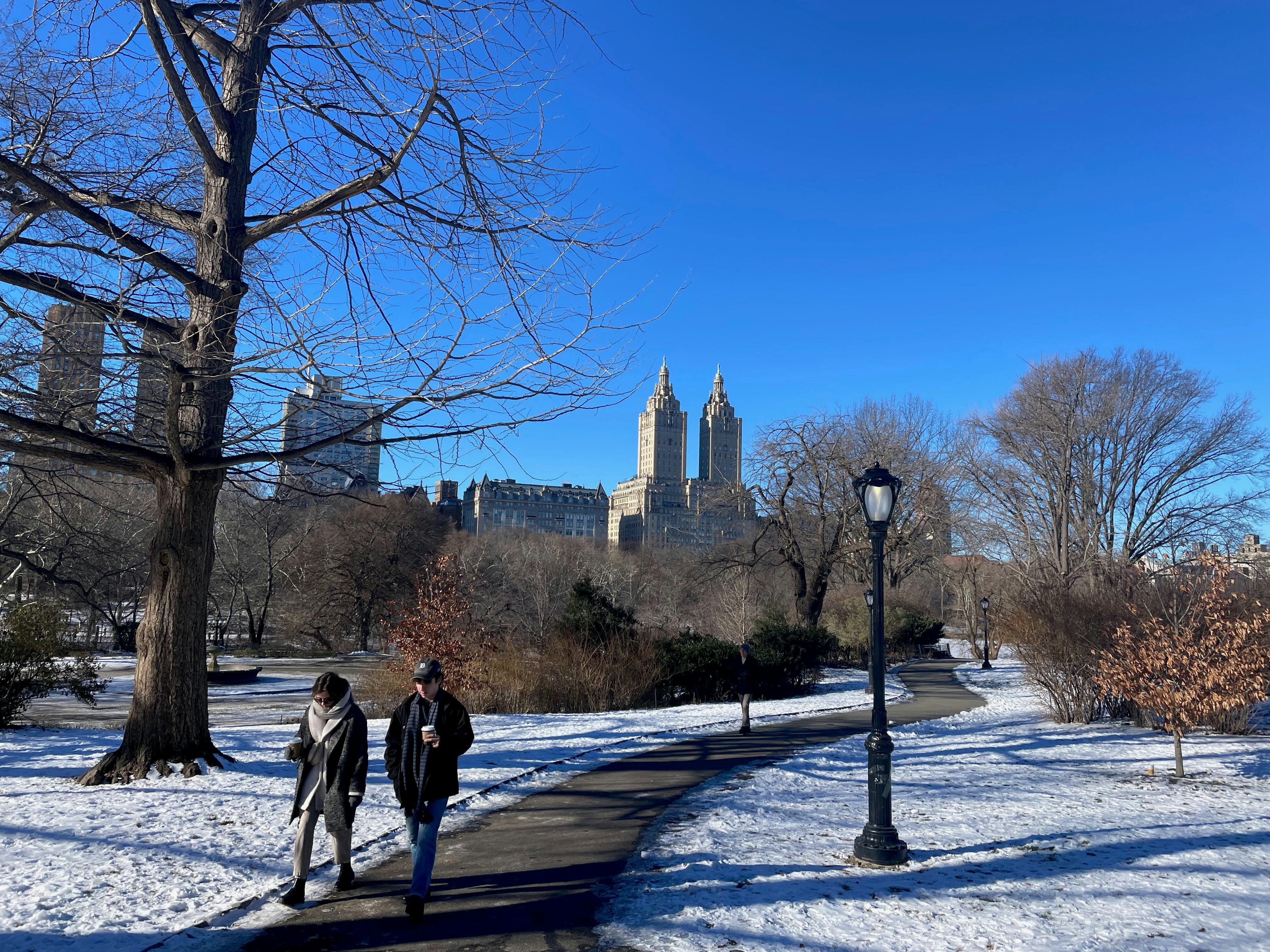 A couple of people walking down a snow covered sidewalk photo – Free ...