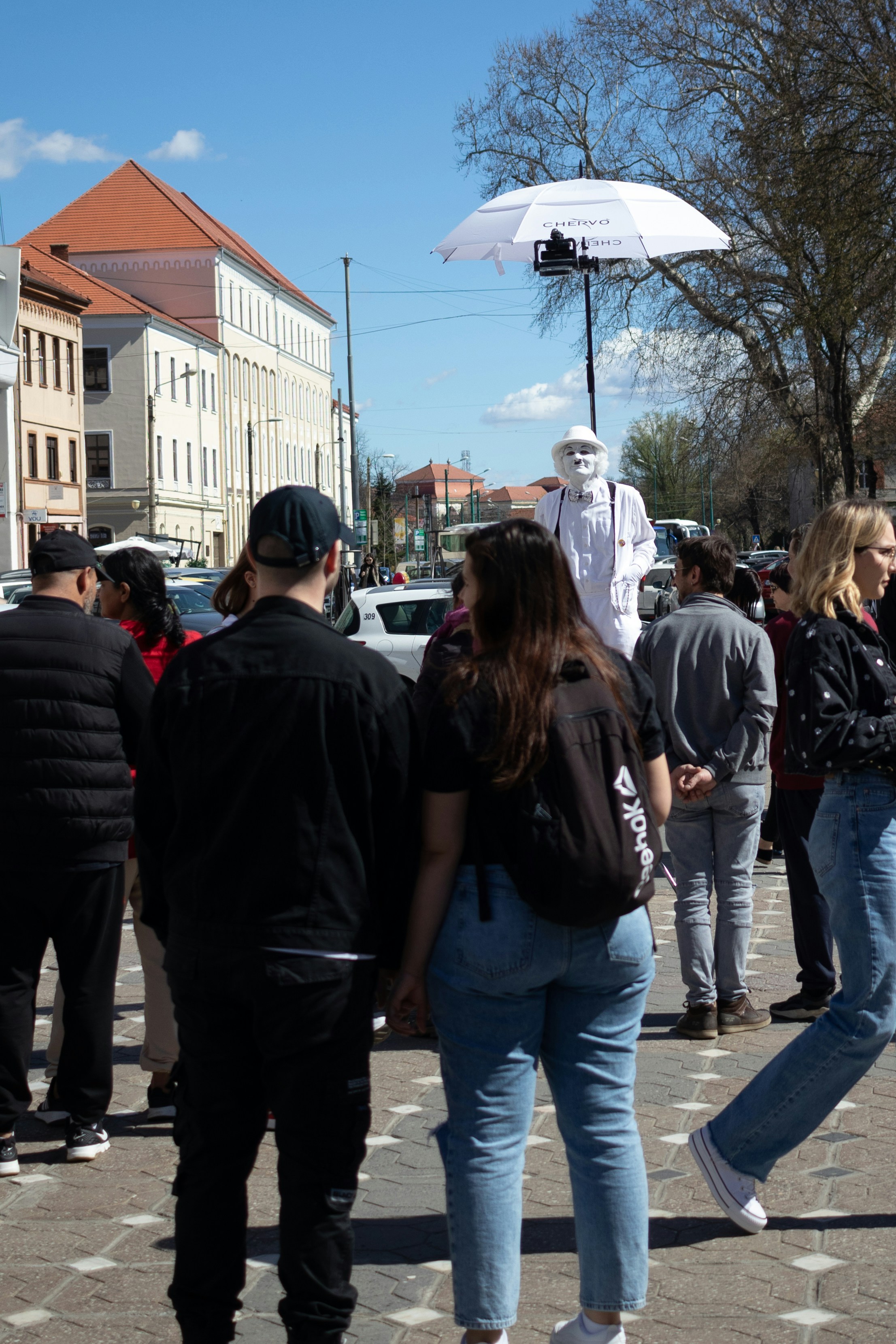 Street Parade: A White-Clad Figure Under an Umbrella Spearheading the Crowd