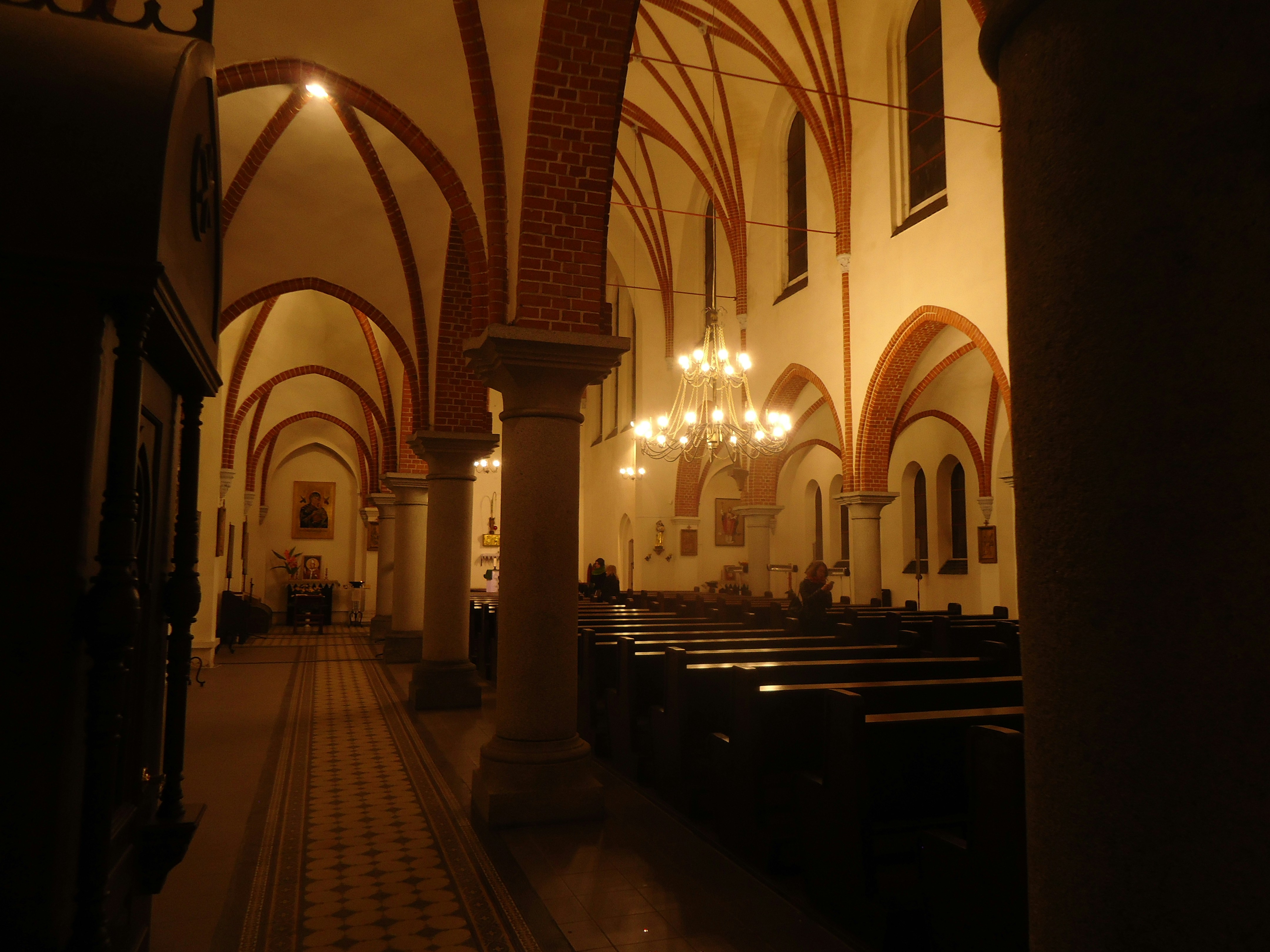 A dimly lit church with chandeliers and pews photo – Free Brown Image ...