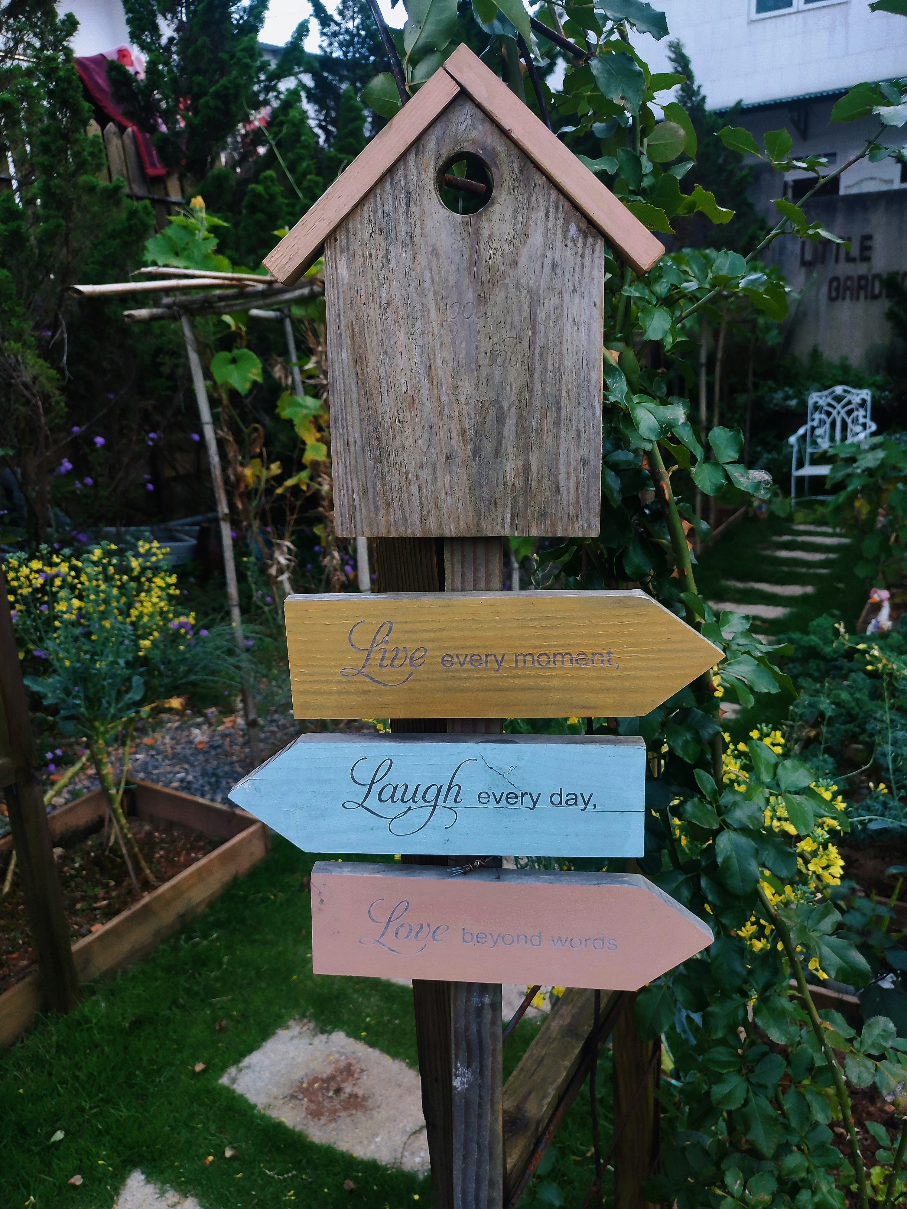 A wooden birdhouse with a sign that says laugh every day photo – Free ...