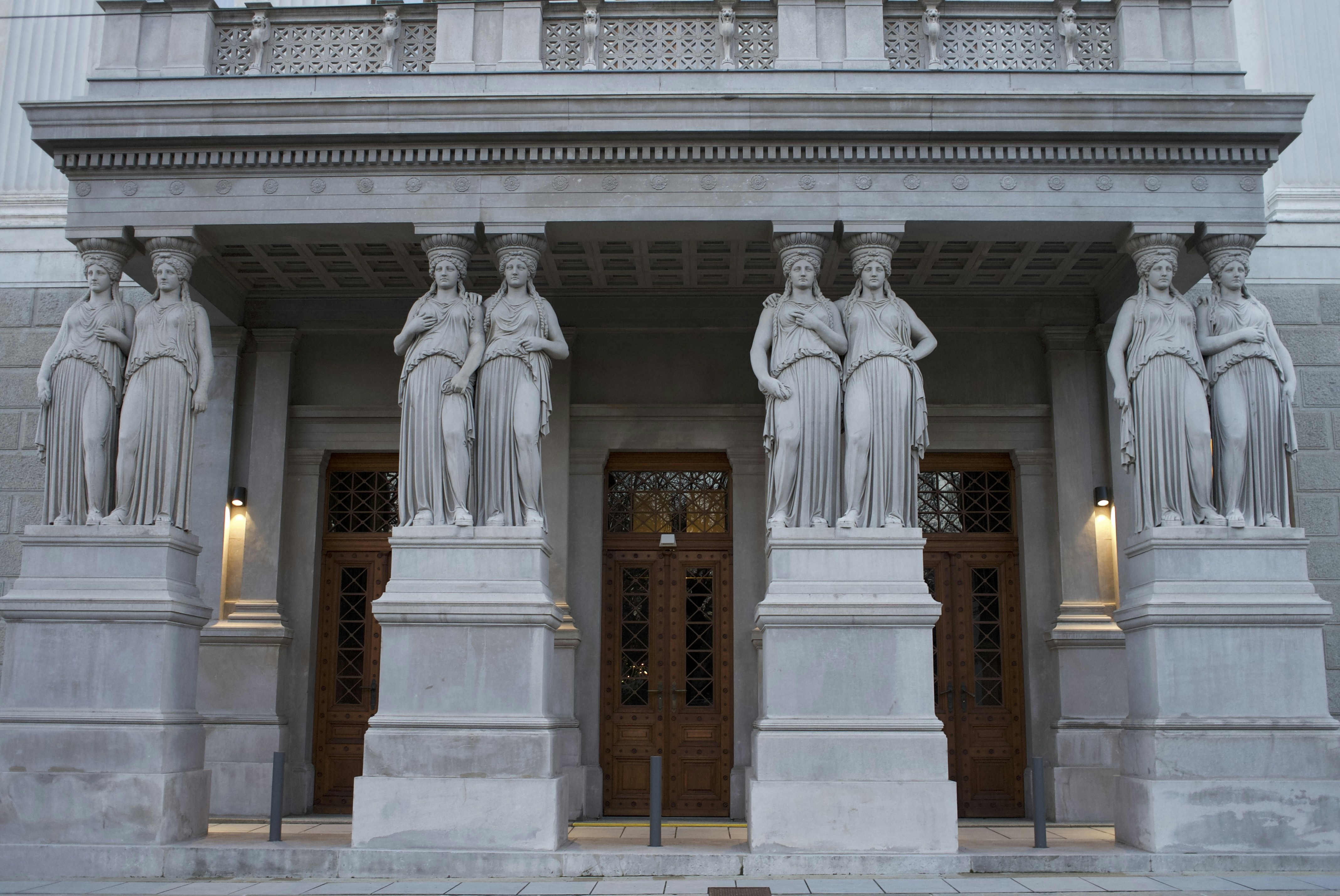 A large building with statues on the front of it photo – Free Building ...