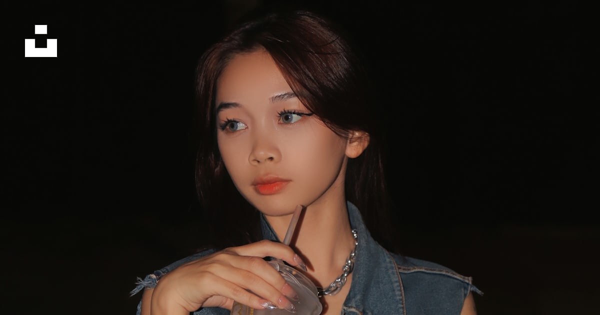 デニムのベストを着た女性が飲み物を手にの写真 Unsplashの無料パンツ写真