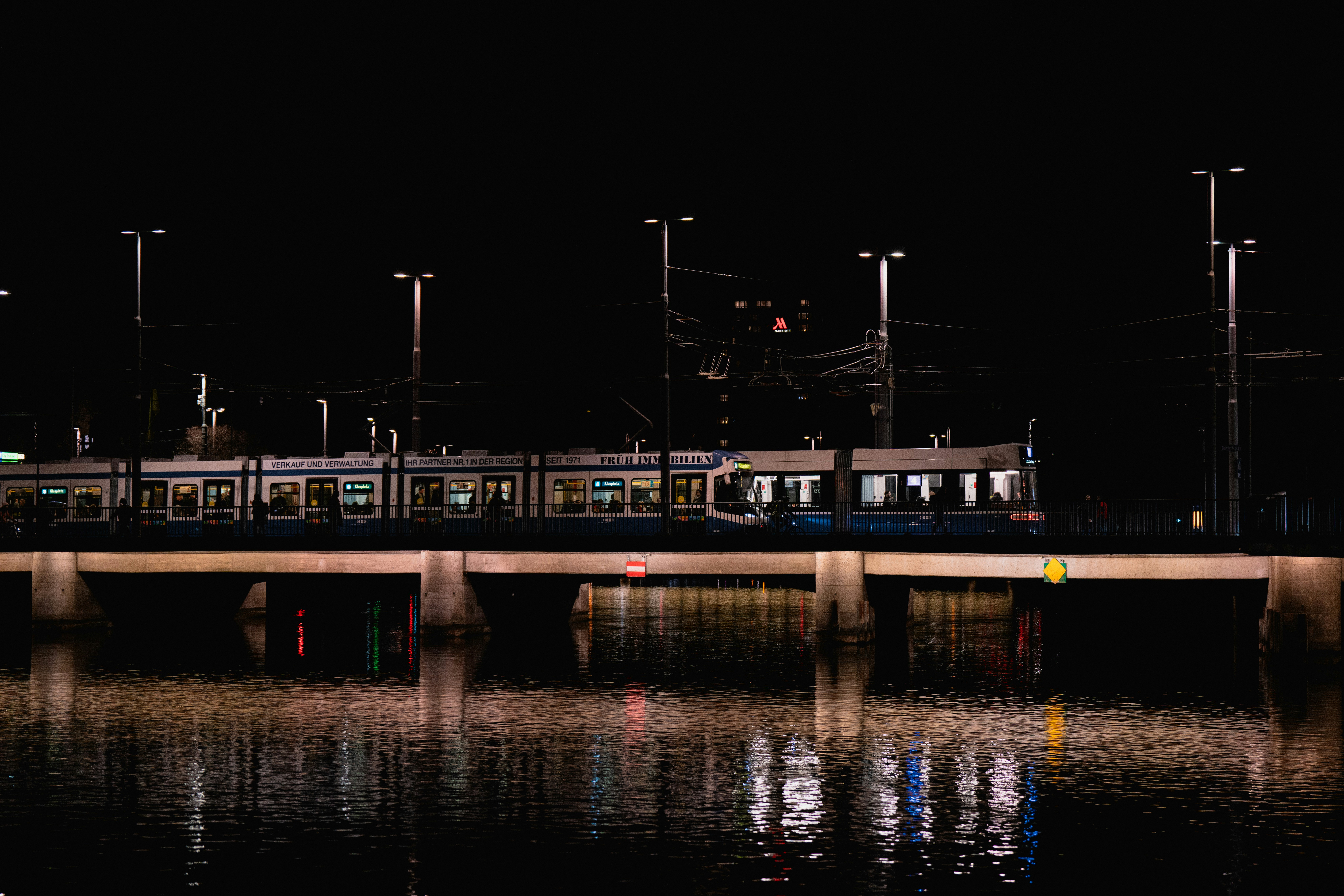 Midnight Train on the River Bridge: Reflections Flicker Across Quiet Water