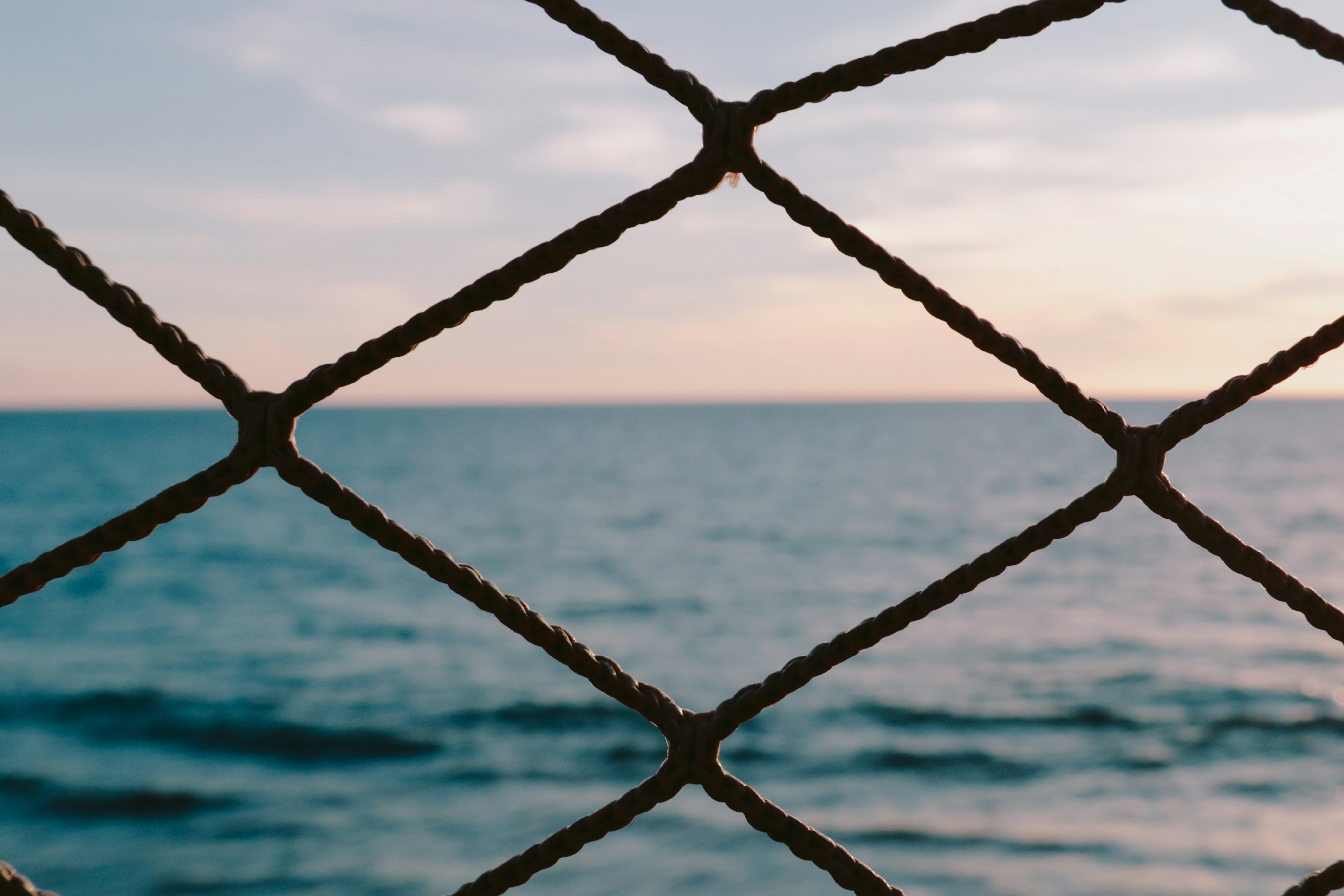 A view of the ocean through a chain link fence photo – Free Italy Image ...