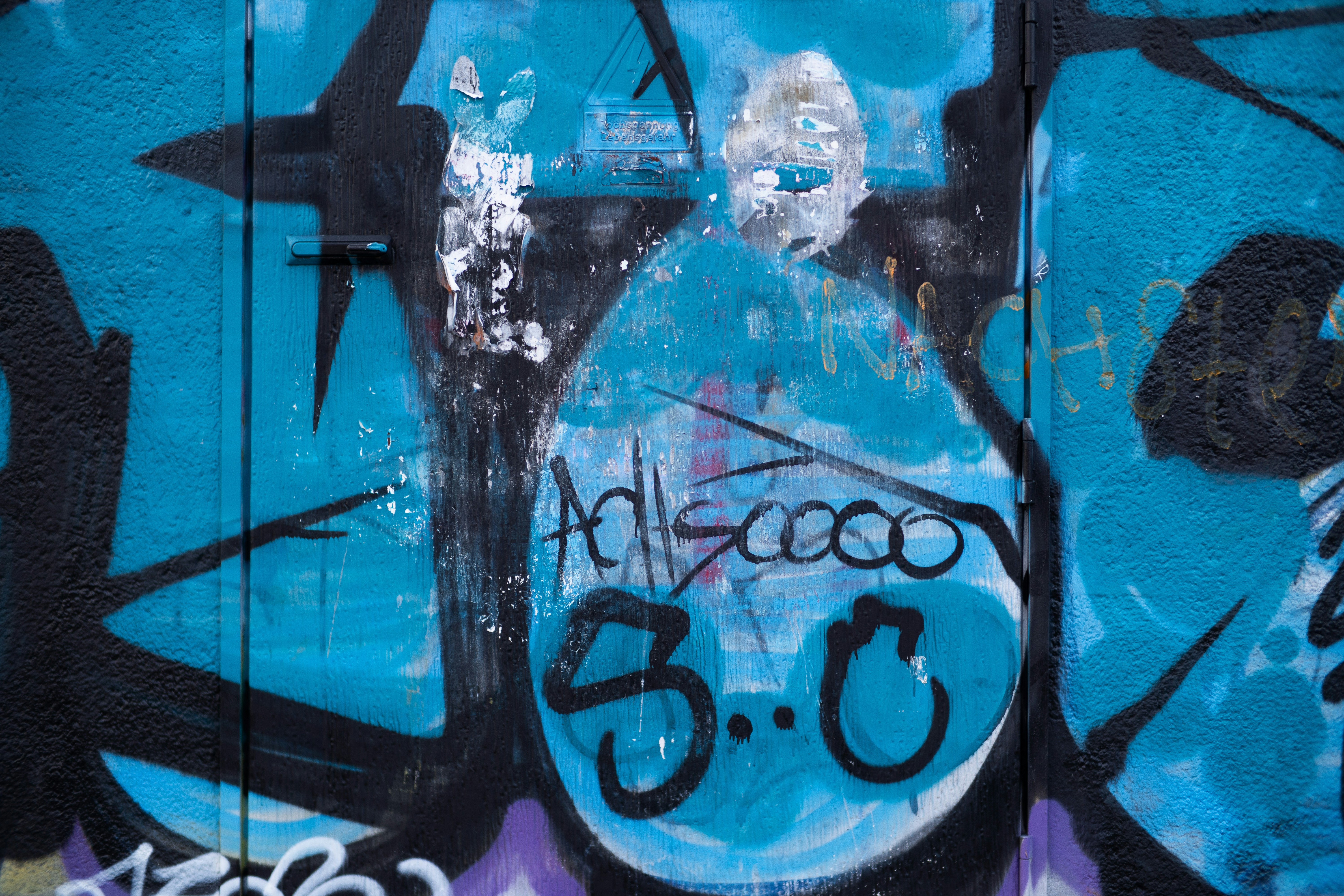 a wall covered in graffiti with a clock on it