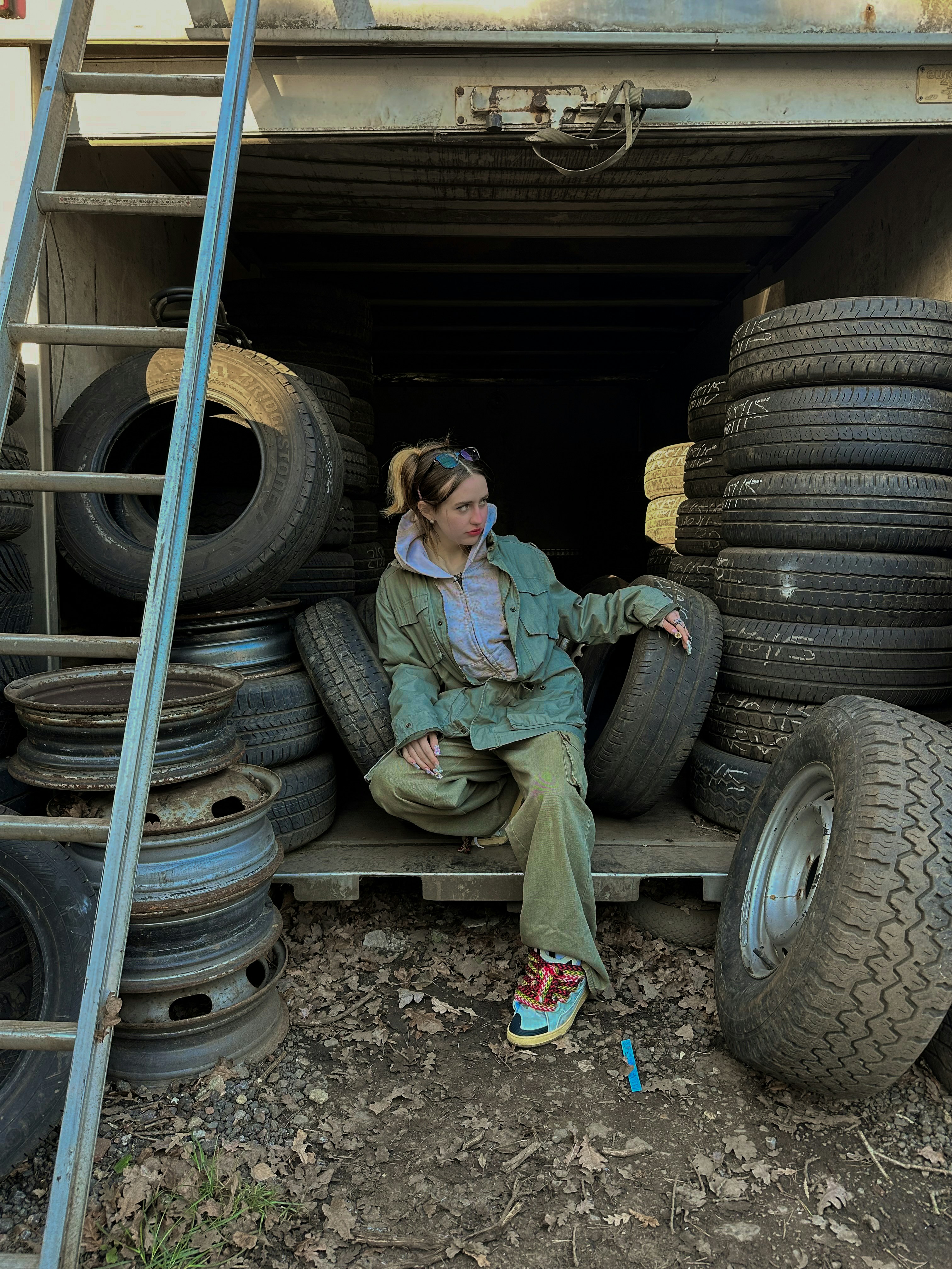 Sitting Among Wheels: A Quiet Portrait in a Tire Yard Garage