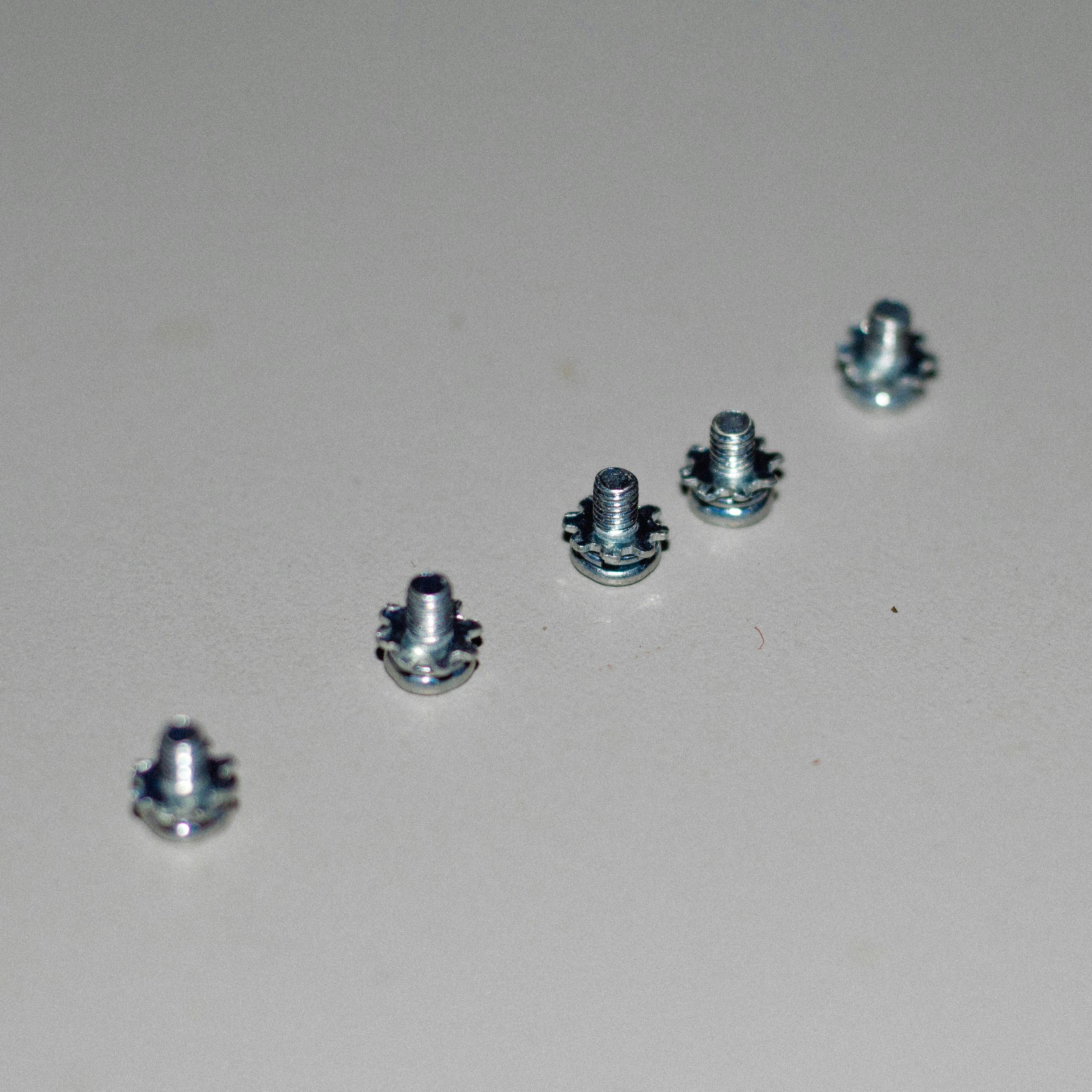 Diagonal Row of Tiny Screws: A Macro Portrait of Hardware