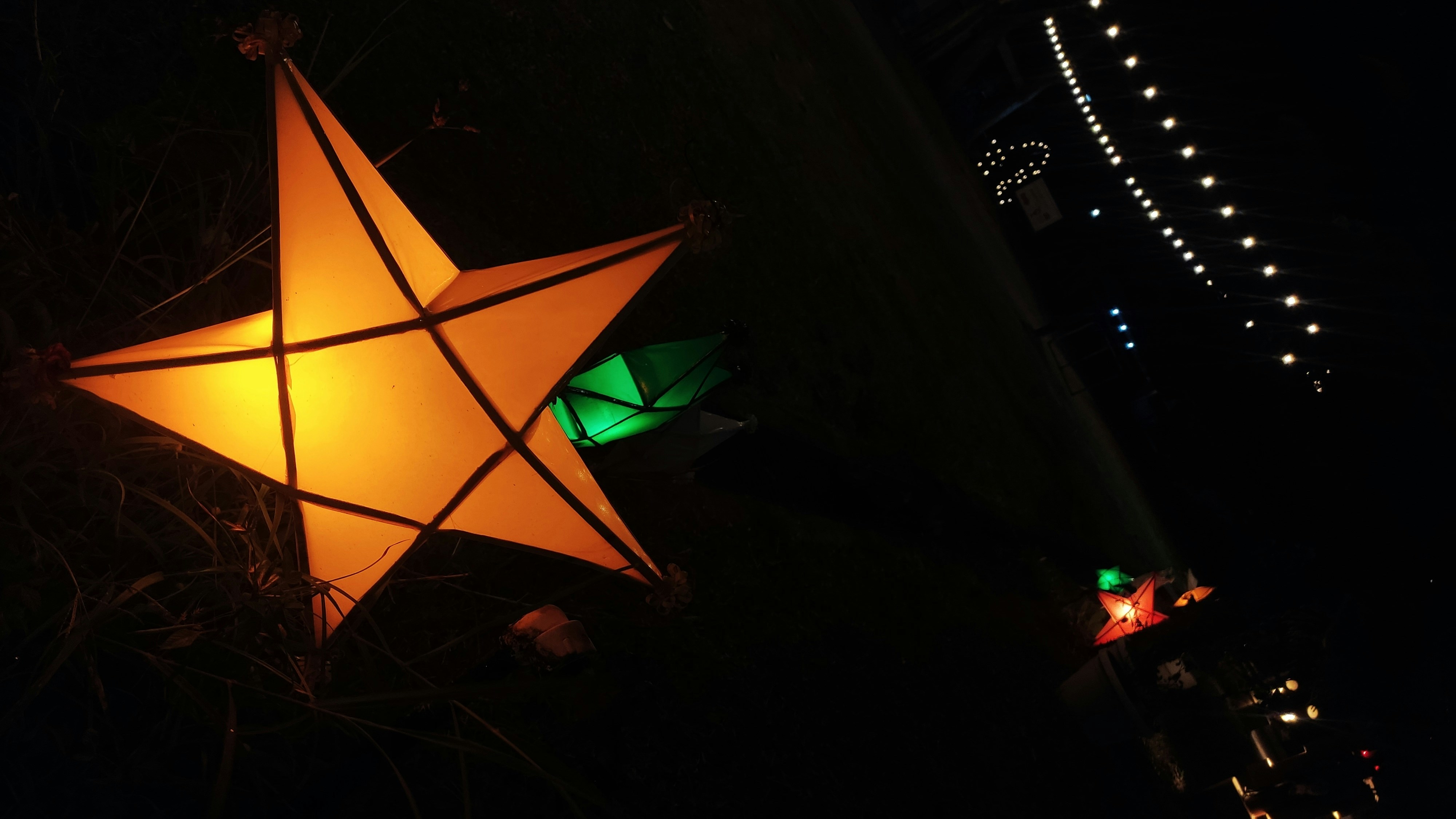 A lighted star hanging from the side of a building photo – Free Brown ...