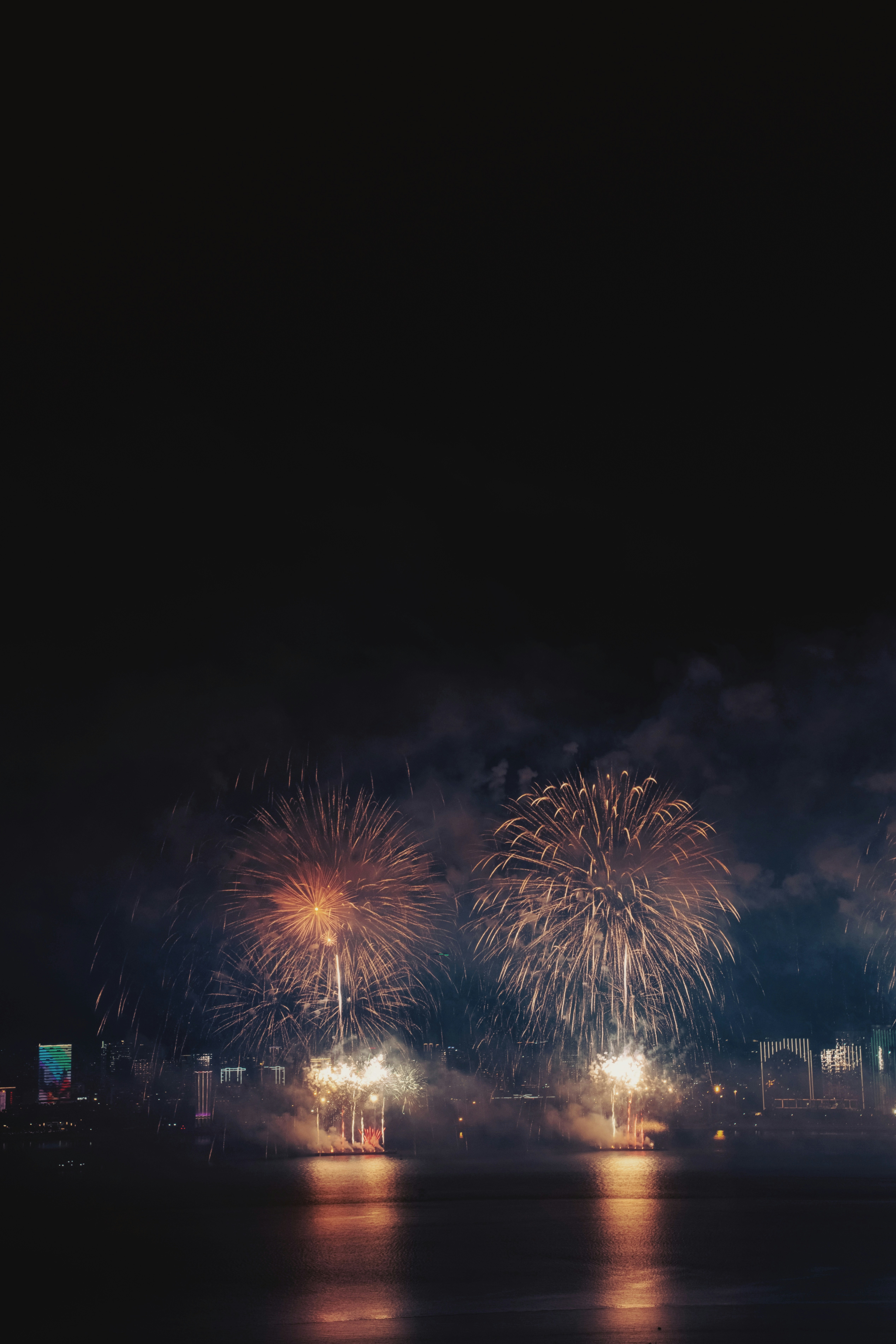 Fireworks are lit up in the night sky over a body of water photo – Free ...