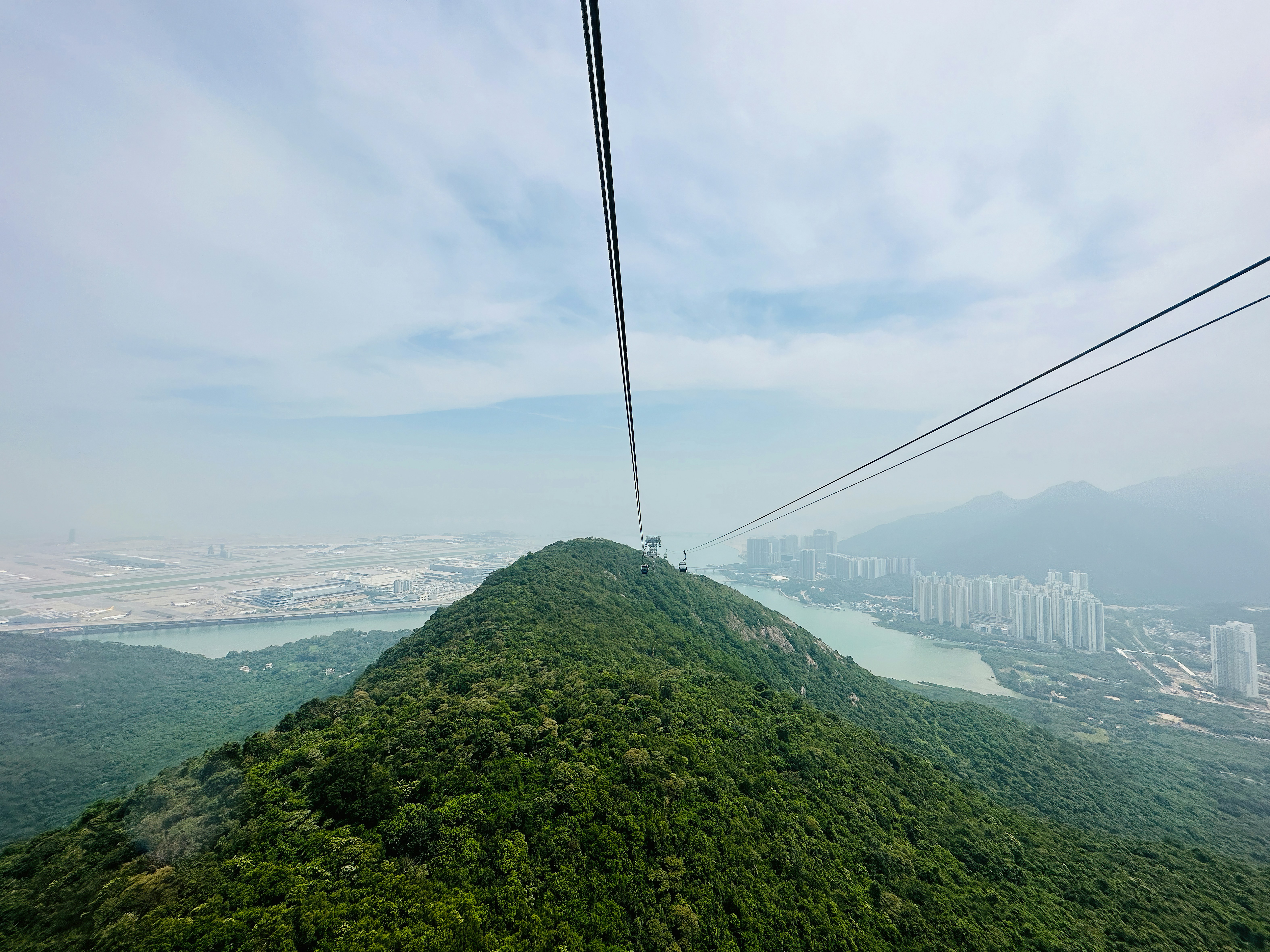 Cable-Car Thread Over Emerald Ridge: City Looms Beyond