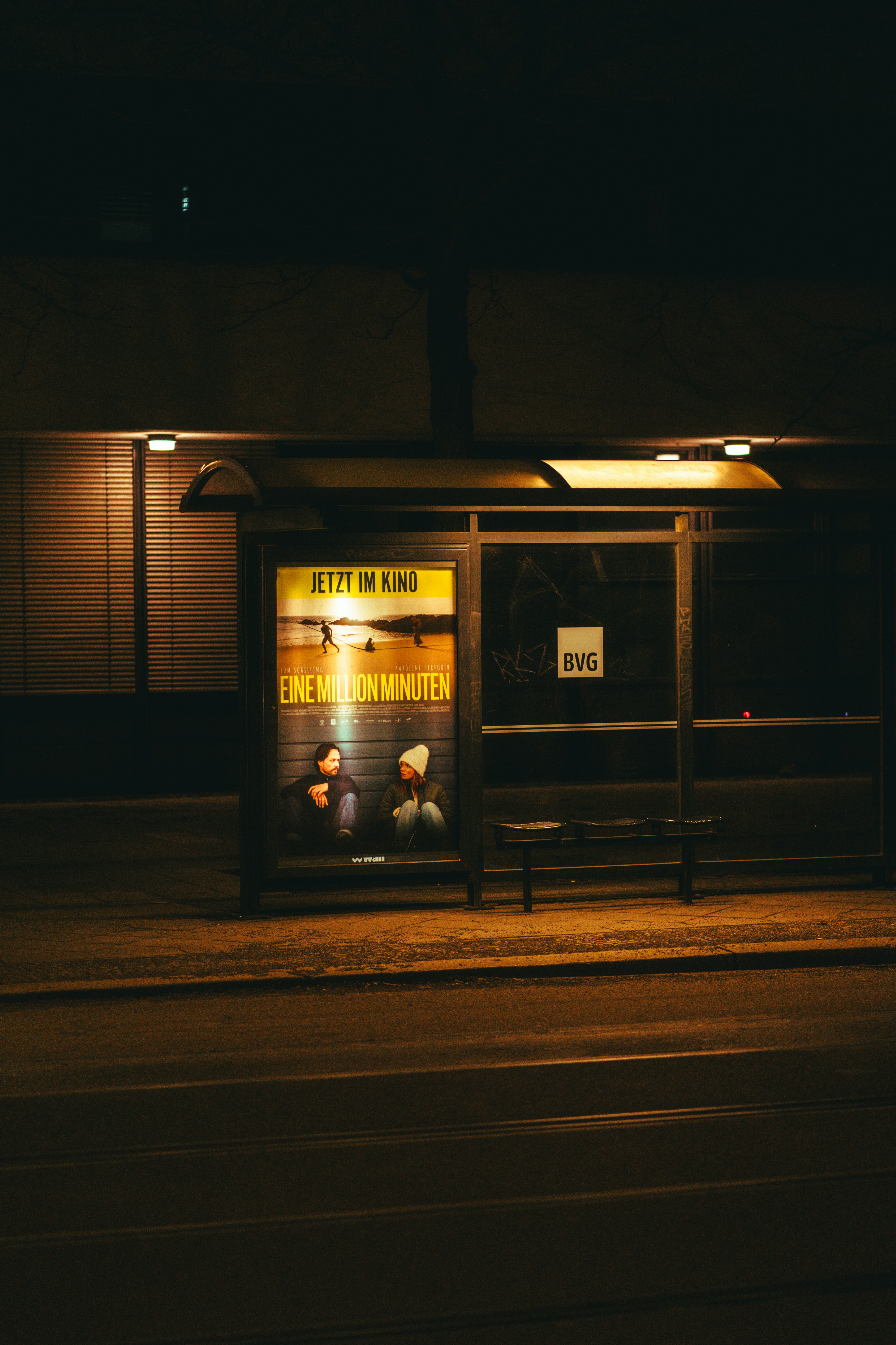 Midnight Screening Under the Bus Stop's Warm Glow