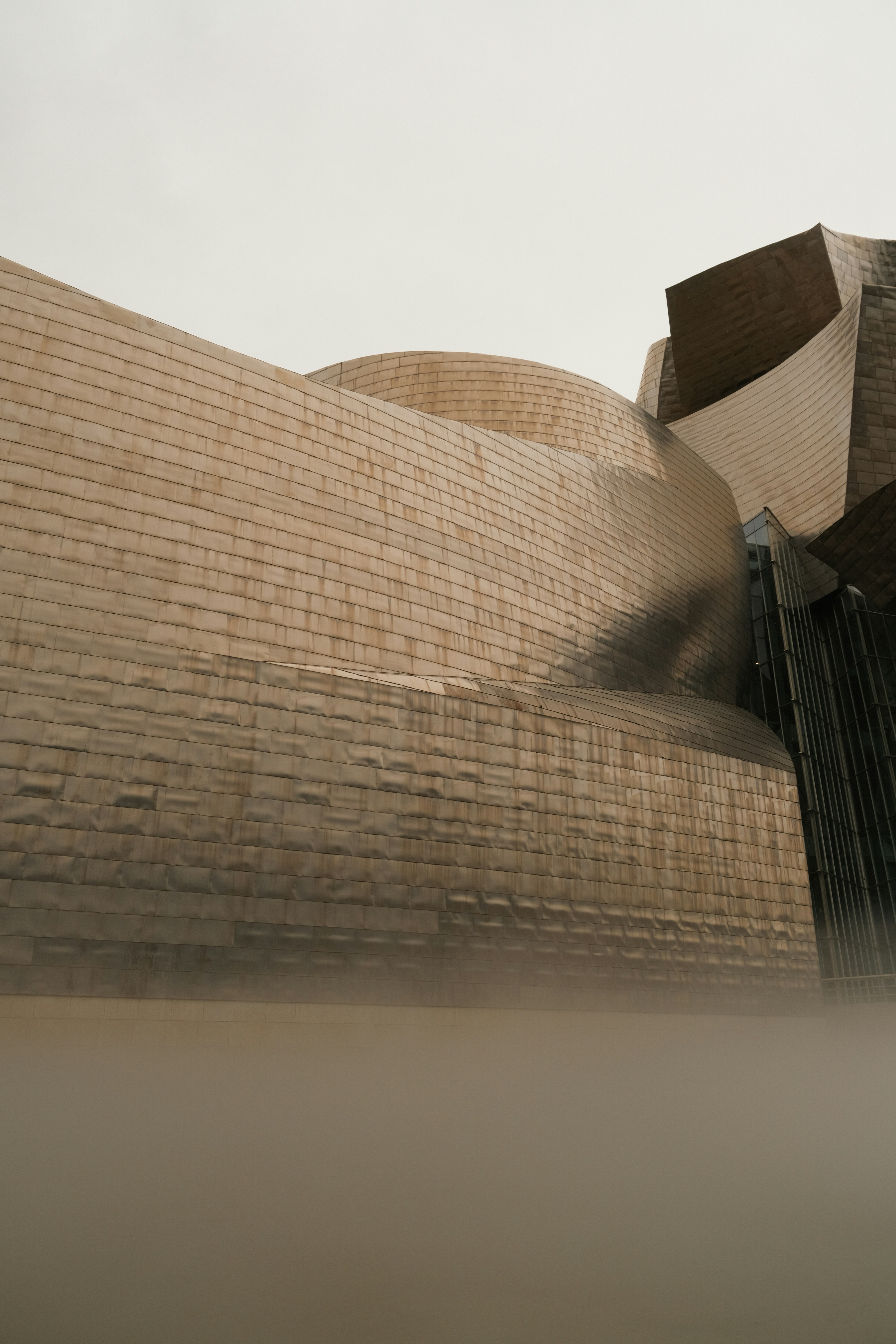 Quiet Curves: Brick and Titanium Converge under a Pale Sky