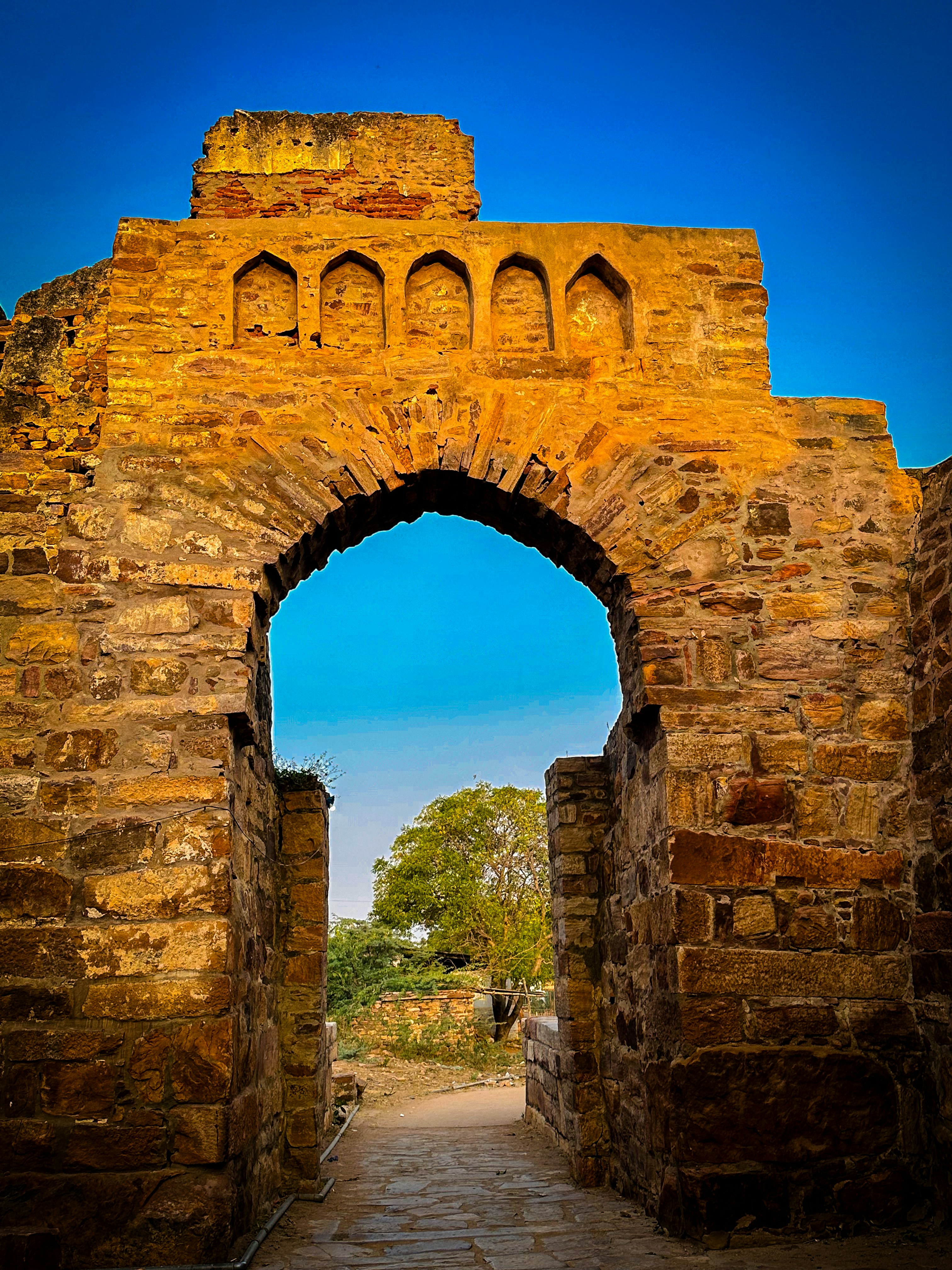 Echoes of Stone: A Sunlit Archway Framing a Quiet Path
