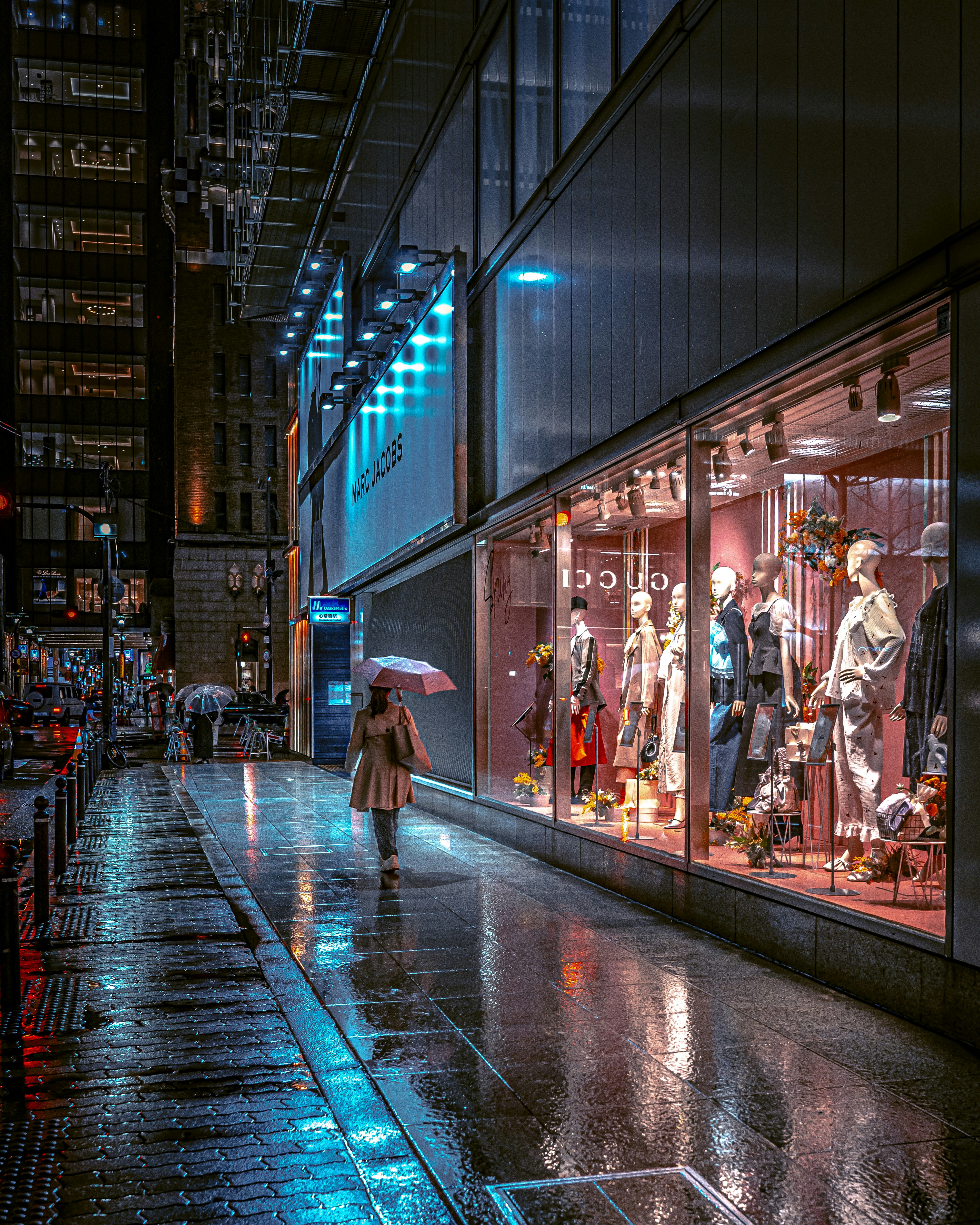 Umbrella under Neon Rain: A Quiet Walk Past a Gleaming Shopfront