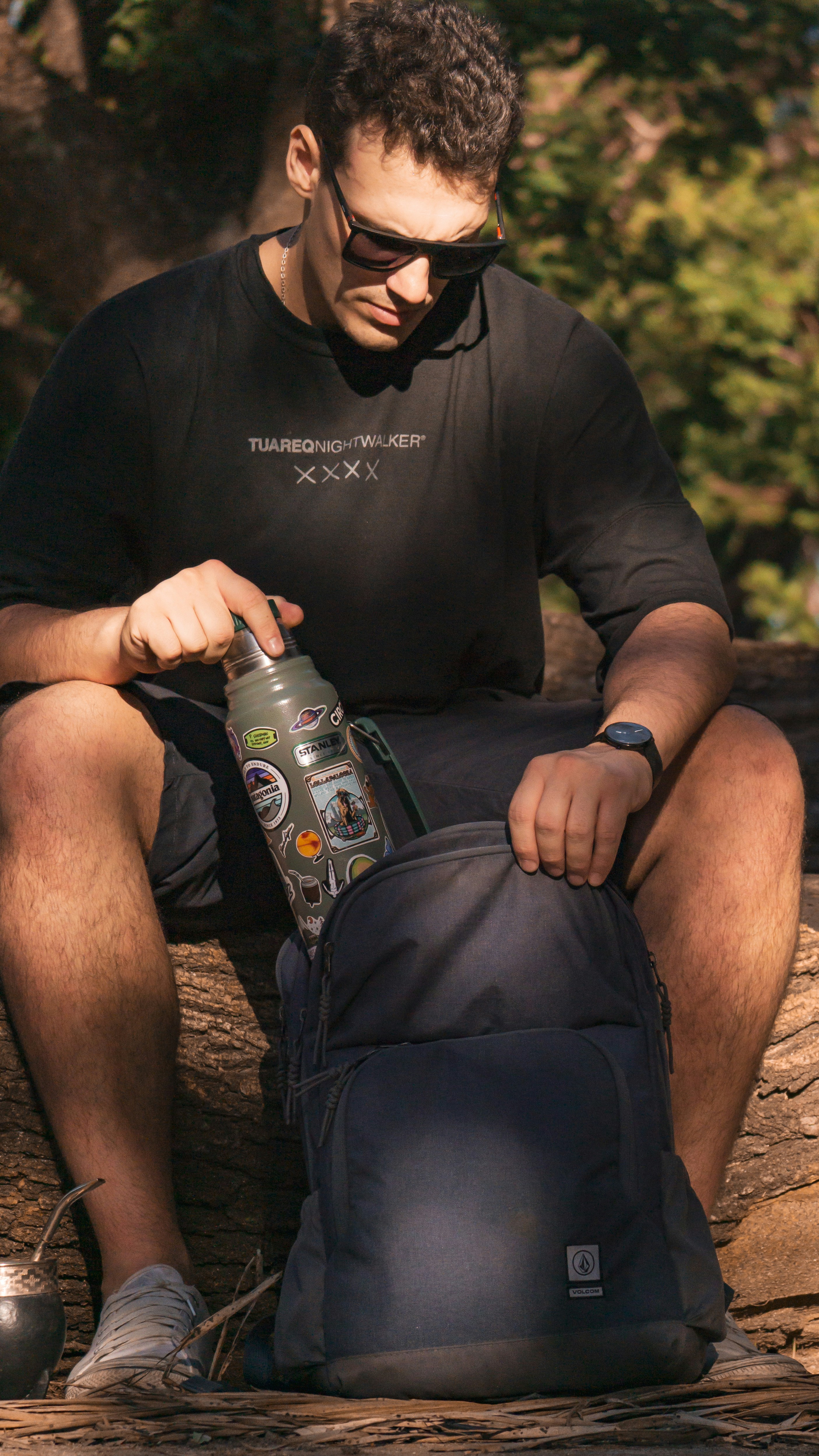 a man sitting on a log with a backpack