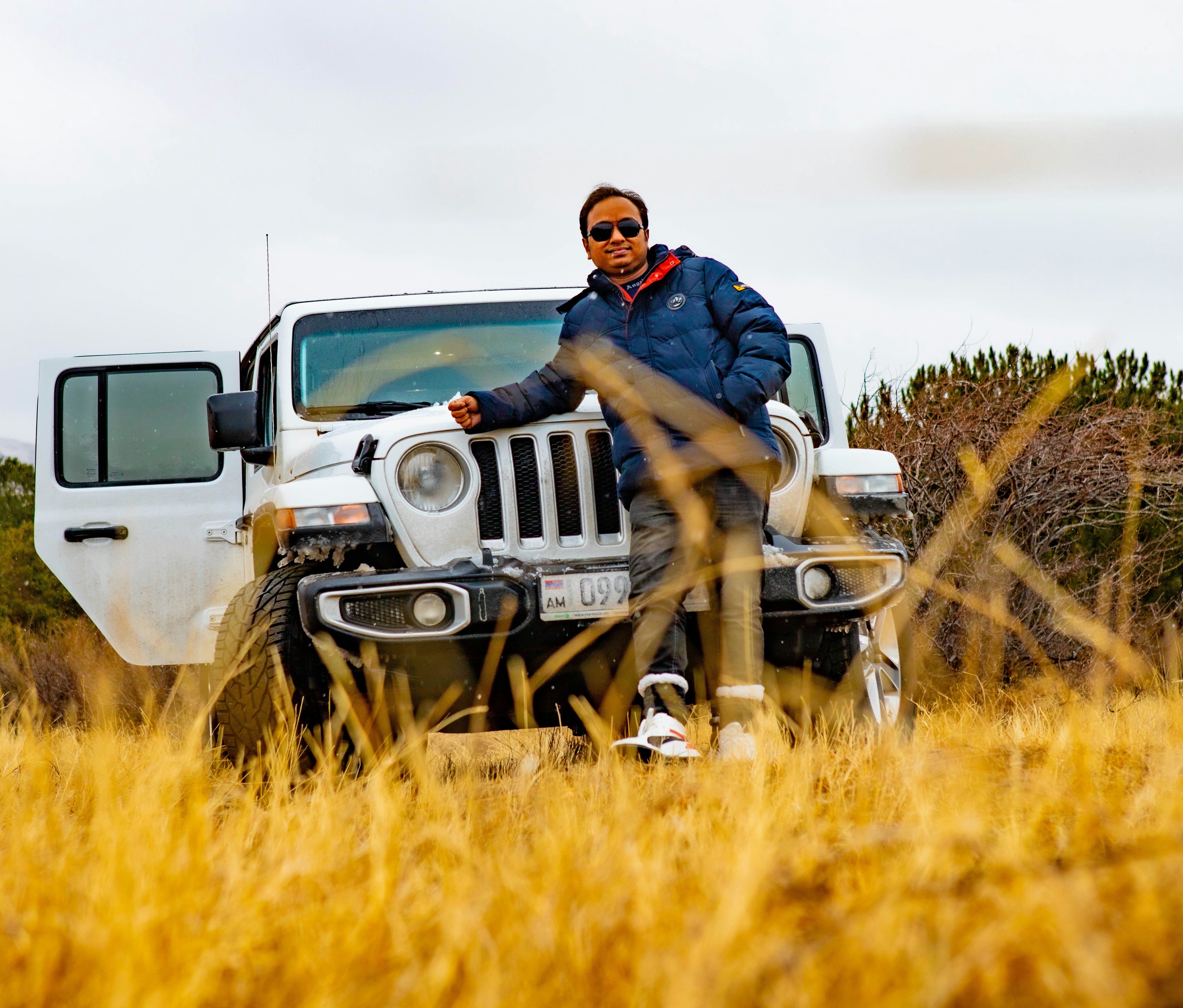 Driver in Blue Jacket Steers a Jeep Into the Golden Field