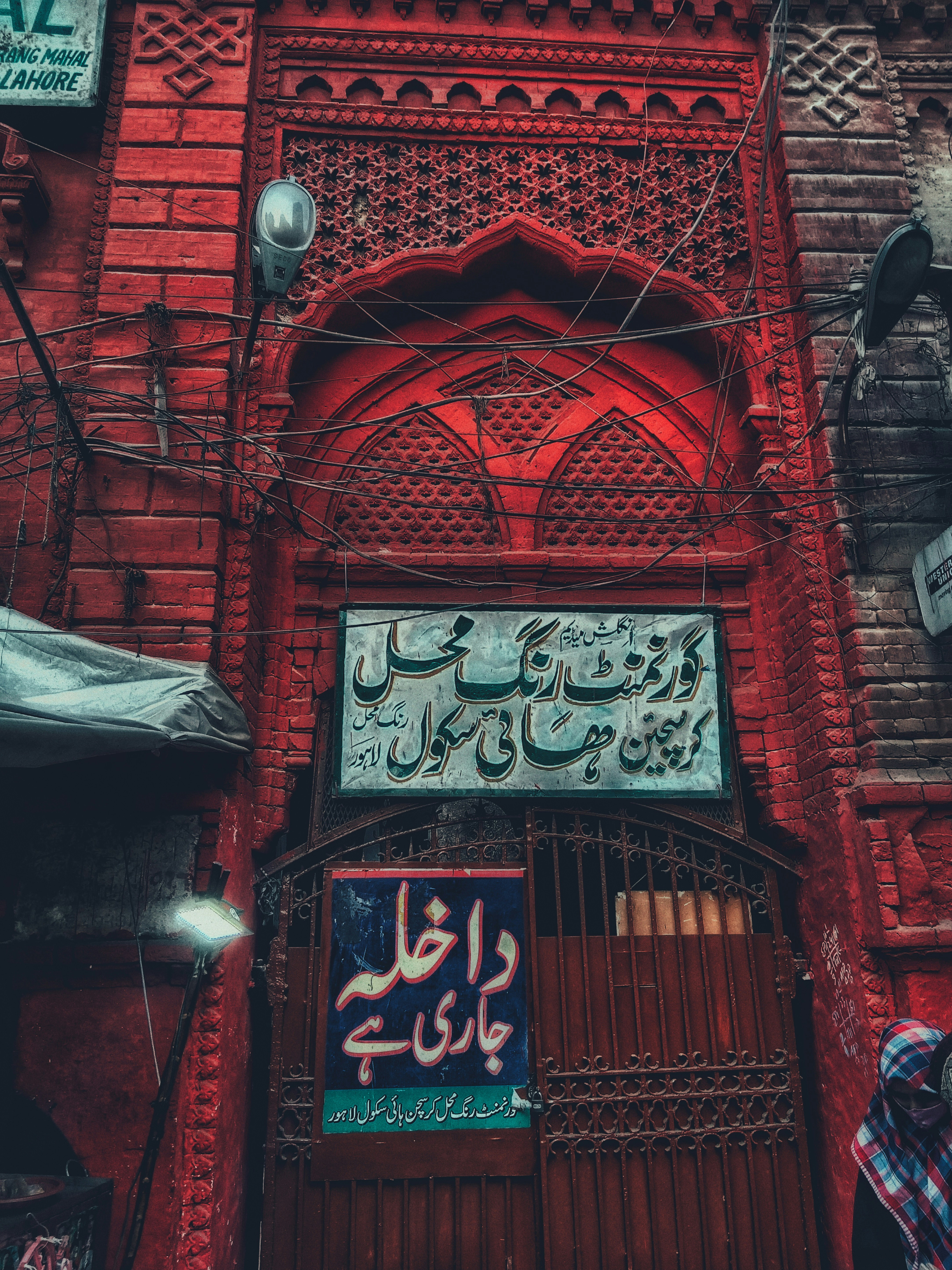 Crimson Archway of Lahore: Wires Weave Through a Historic Facade