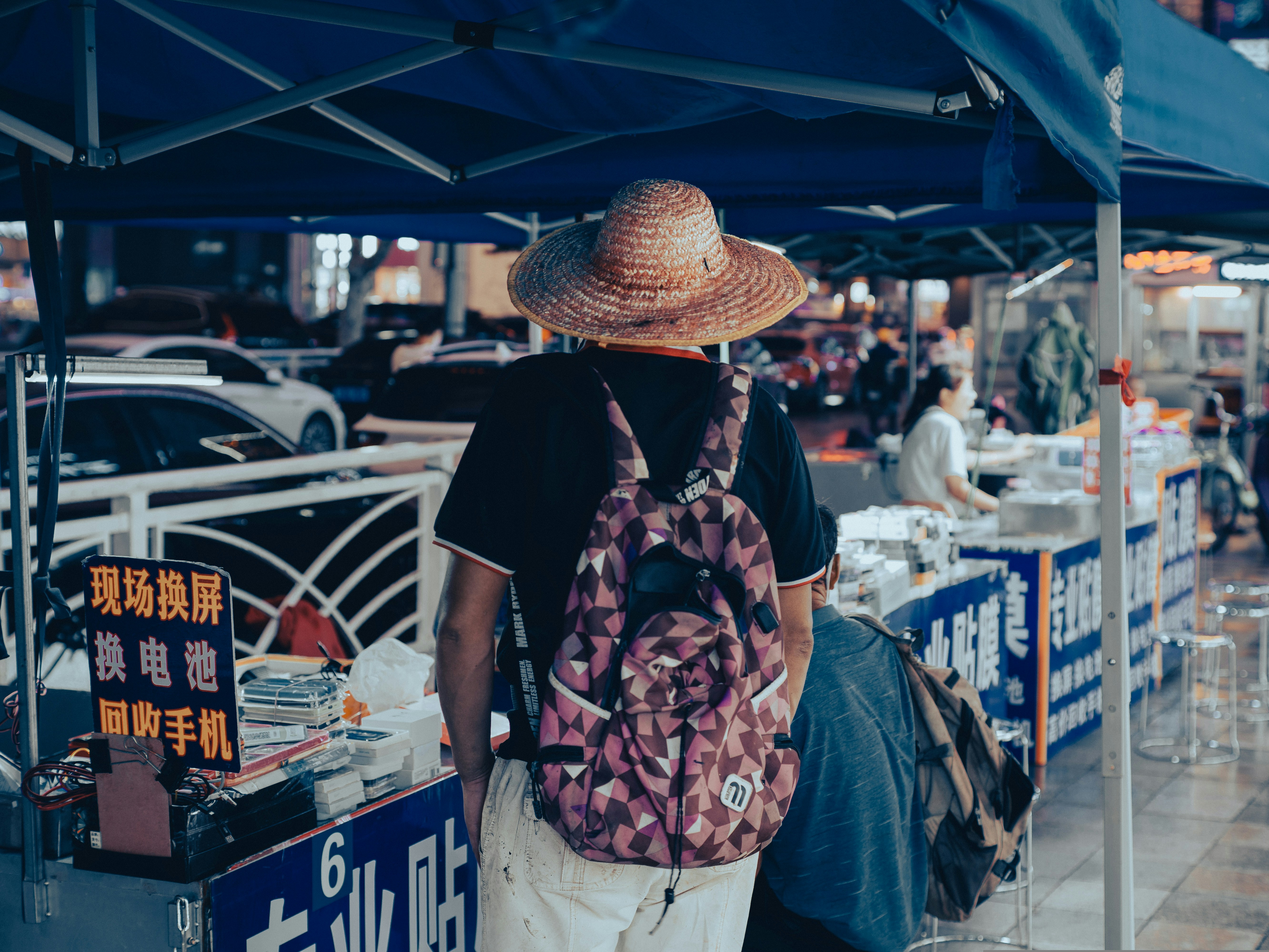 Straw Hat Wanderer with a Geometric Backpack at a Busy Market
