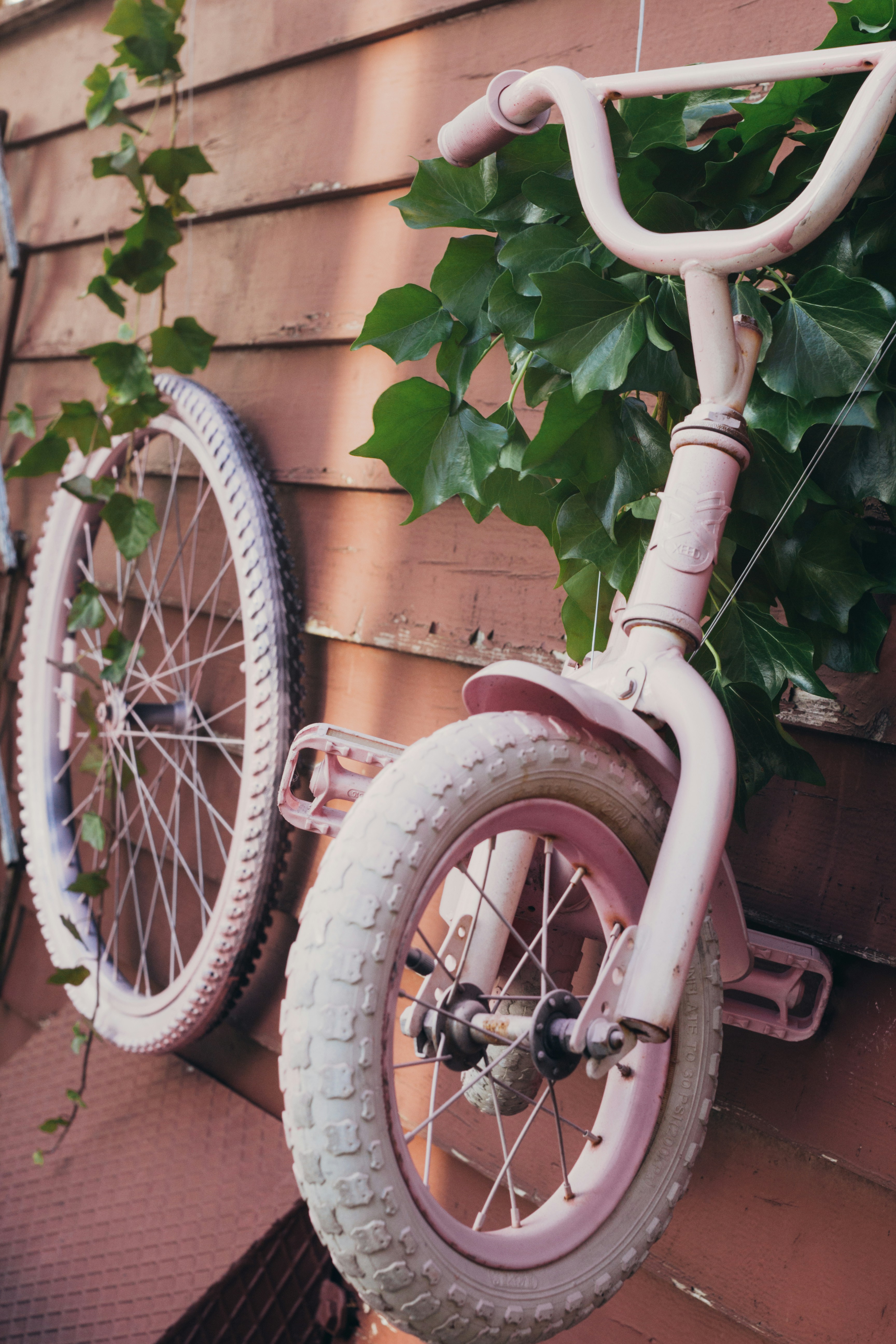pink bicycle on a wooden wall as a decor