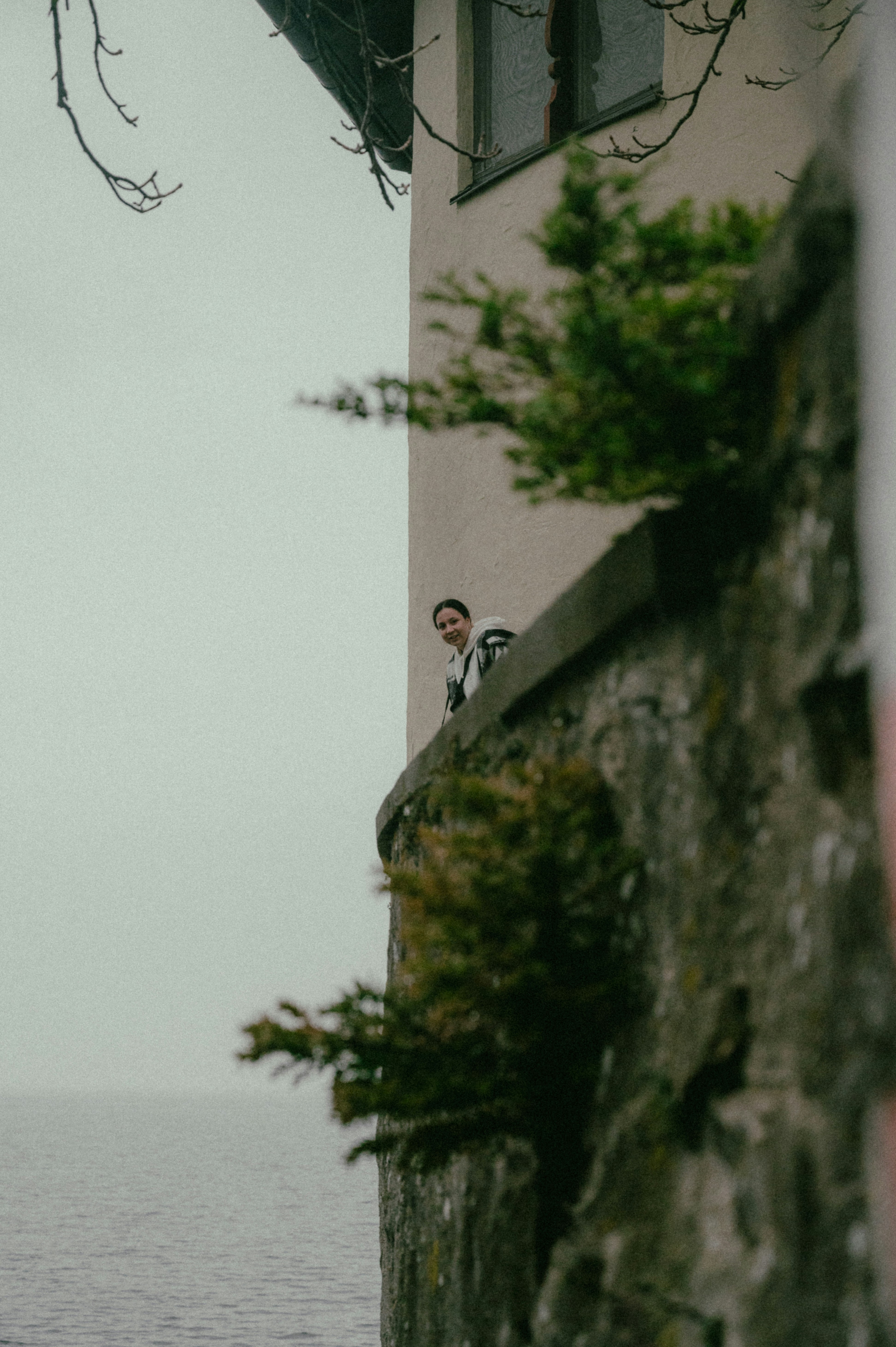 Over the Balcony's Edge: A Quiet Exchange by the Sea