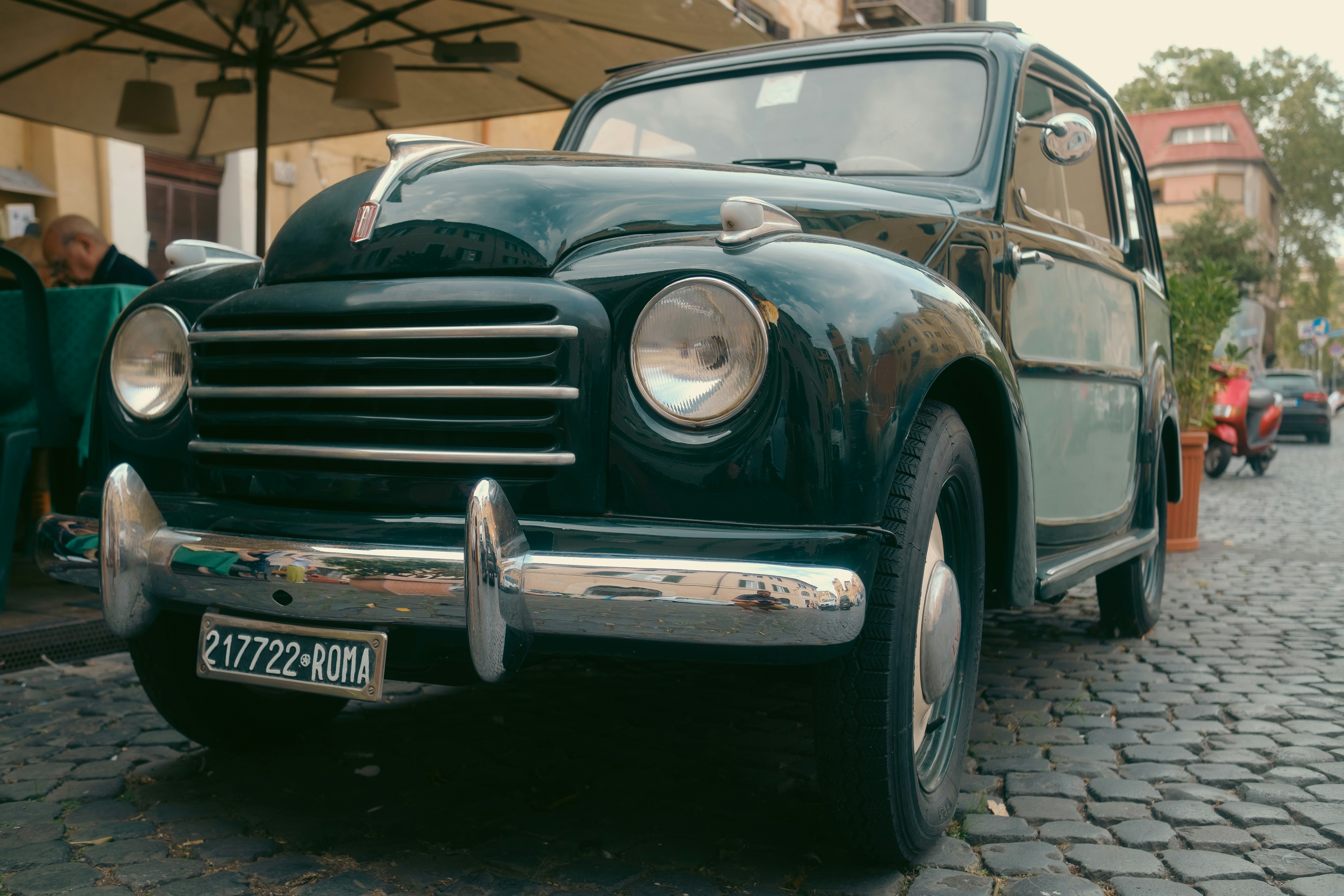 Green Classic in Cobblestones: A Timeless Sedan’s Quiet Stance