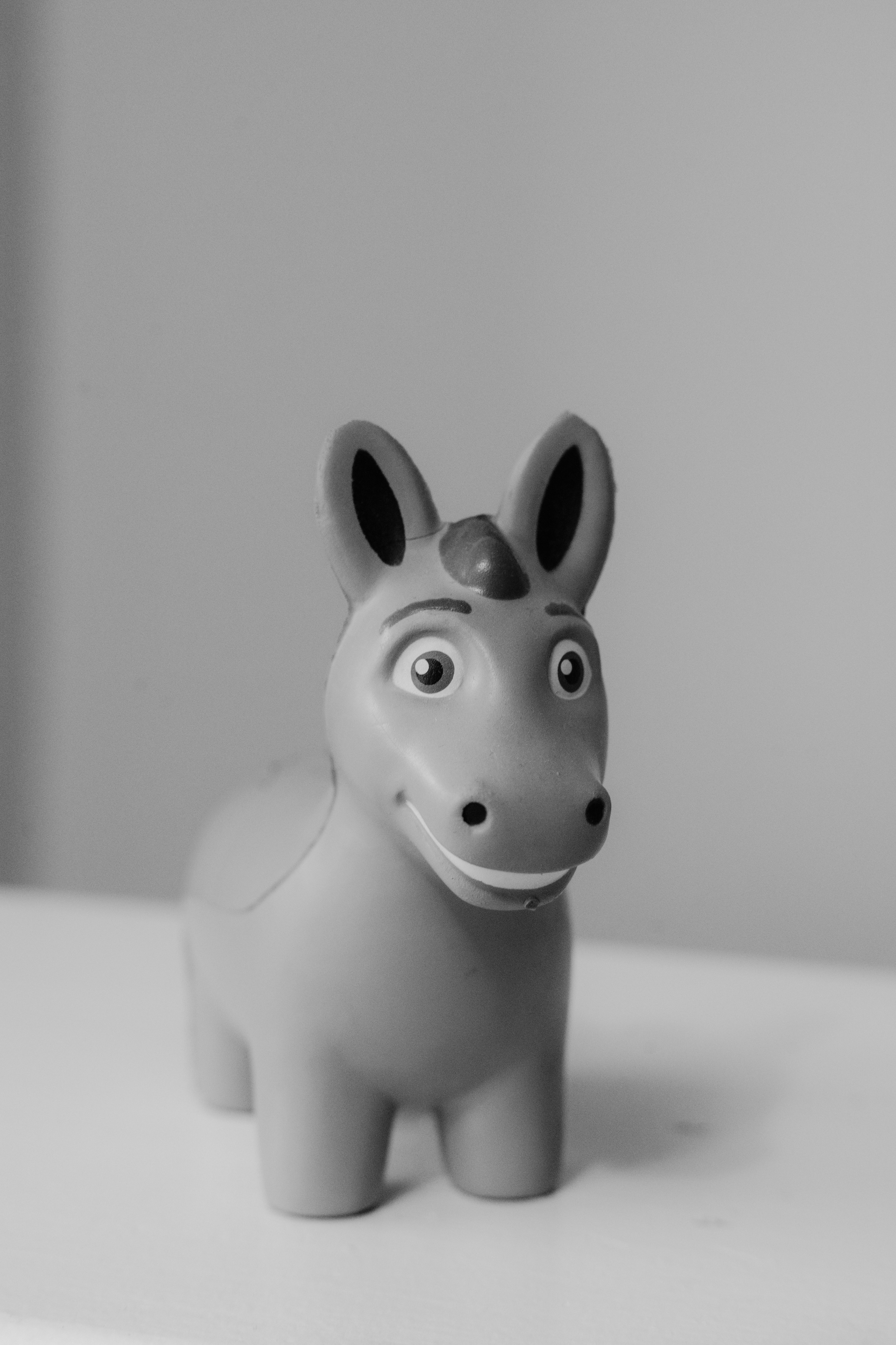 A small toy donkey sitting on top of a table photo – Free Grey Image on ...