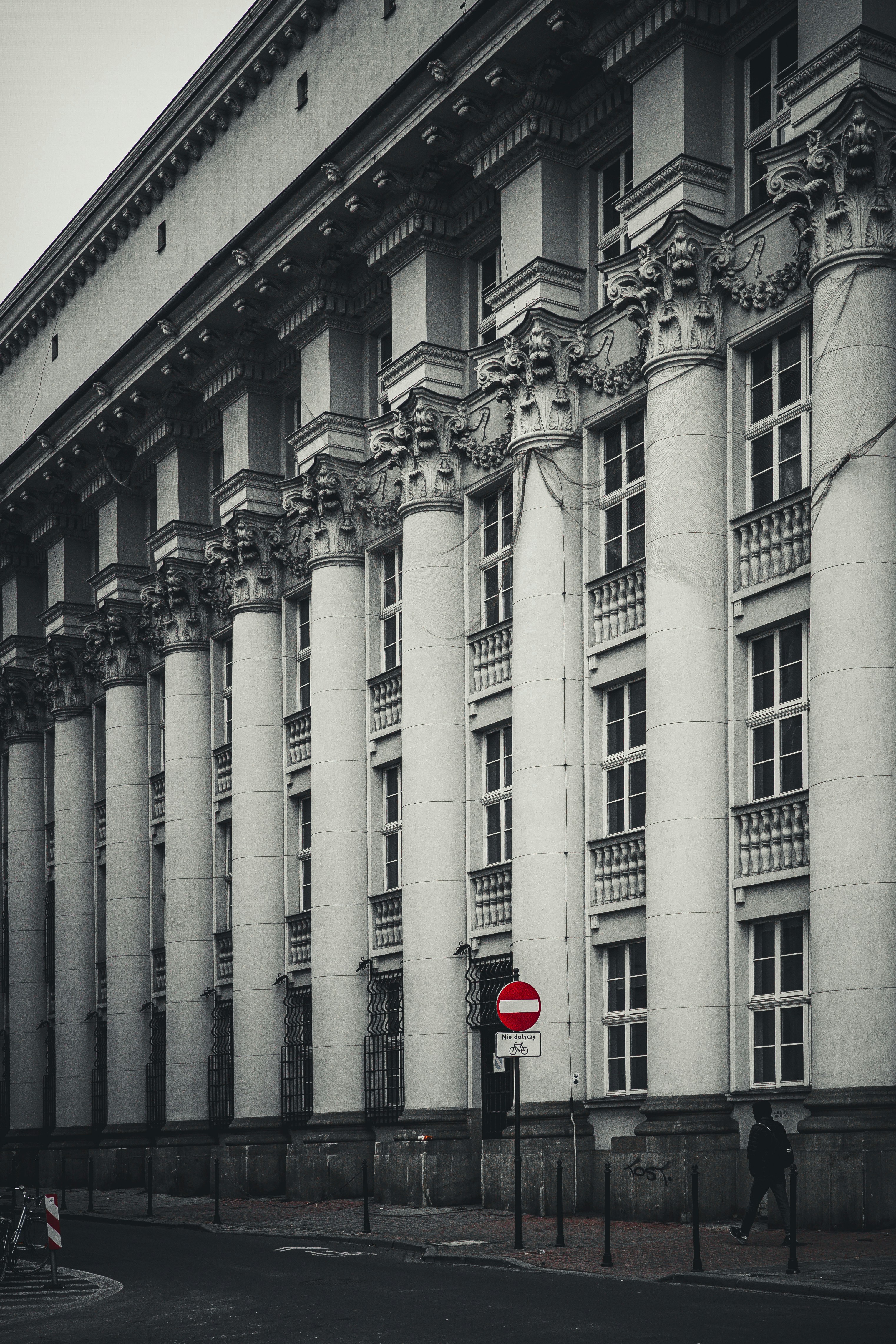 A red stop sign sitting in front of a tall building photo – Free Poland ...