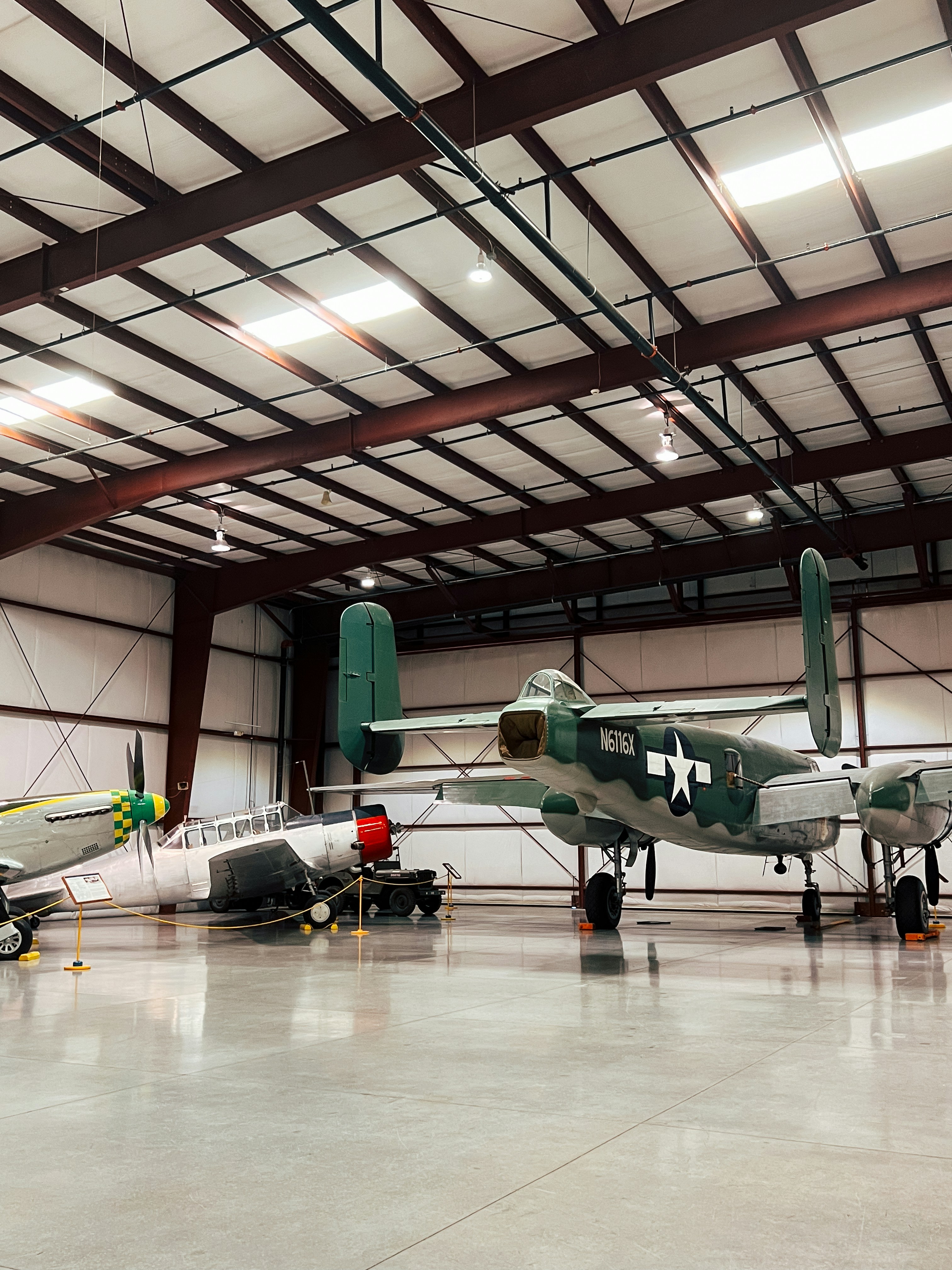 Two vintage aircraft displayed in a spacious hangar, showcasing their unique designs and historical significance.