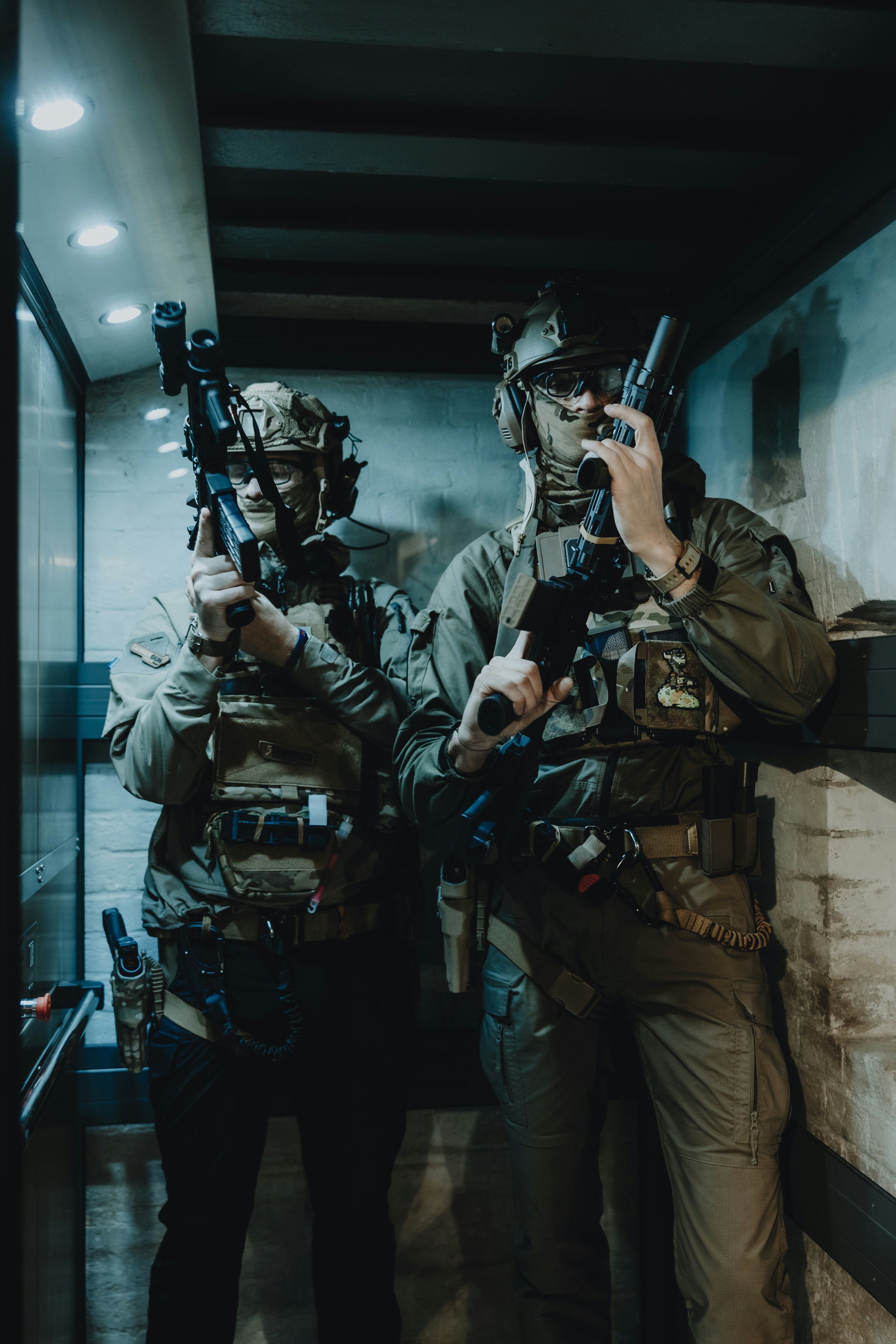 A couple of men standing next to each other holding guns photo – Free ...
