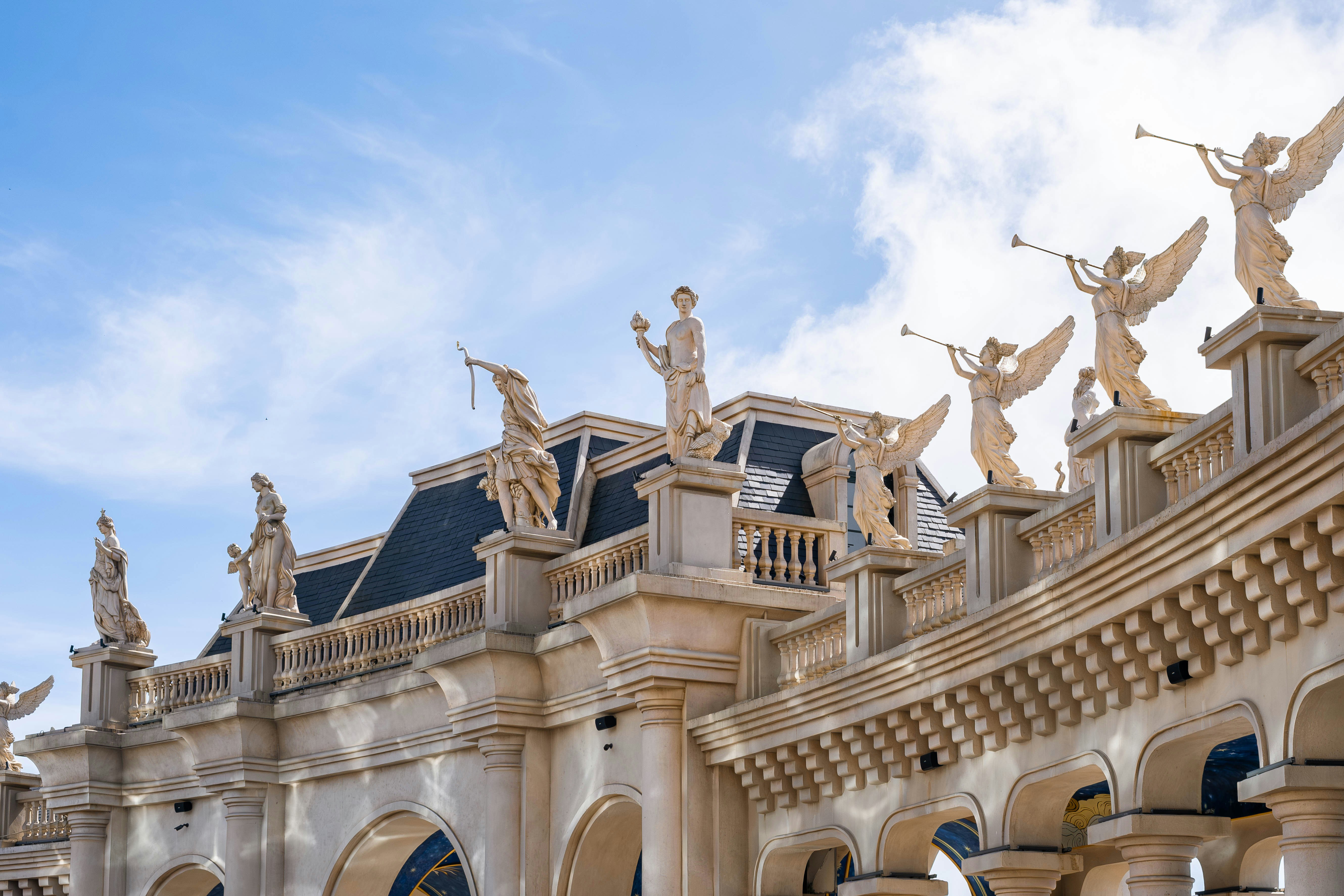 A large building with statues on top of it photo – Free Statue Image on ...