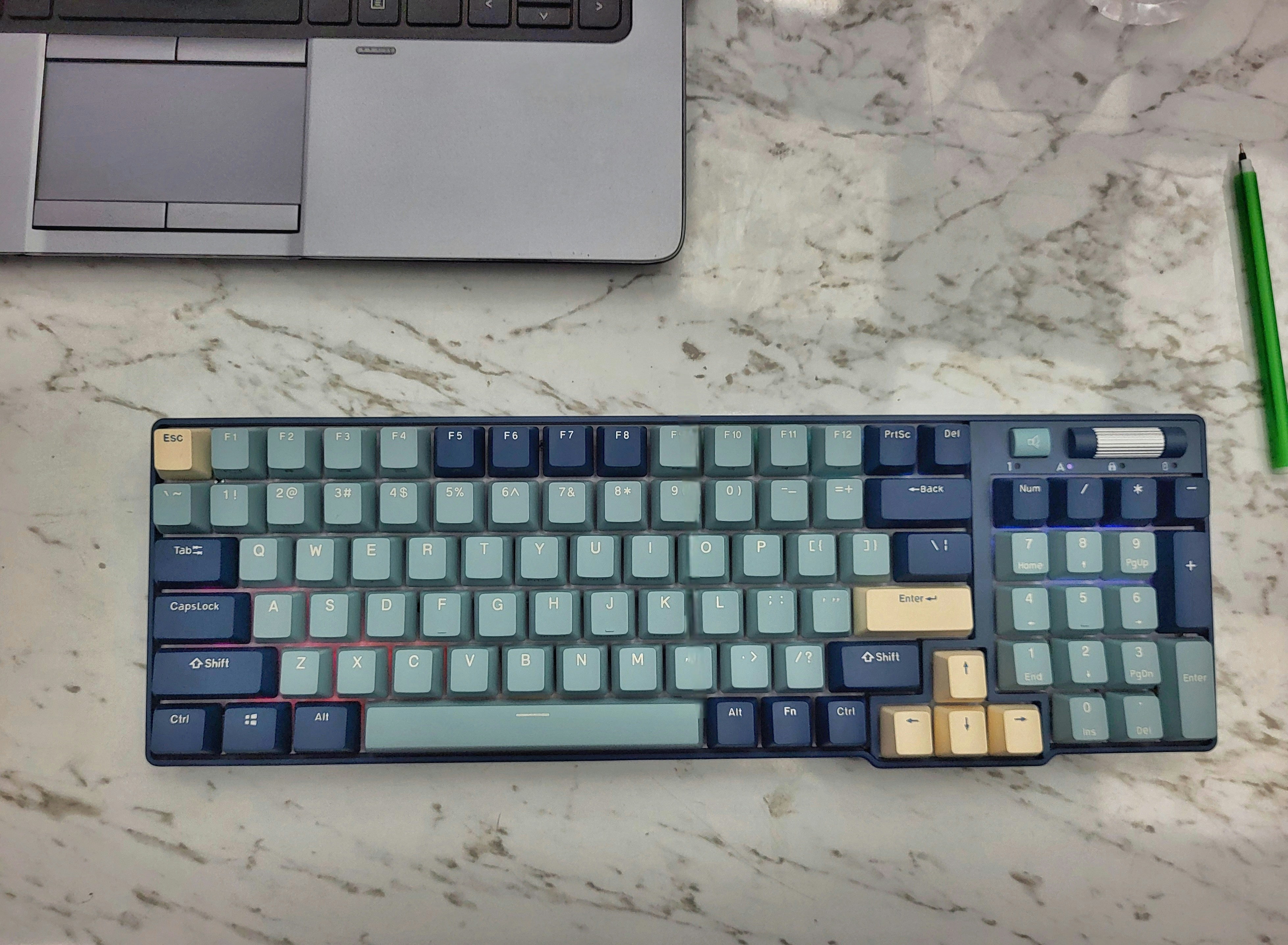 Pastel Keycap Mosaic on Marble Desk: Keyboard Spotlight with a Laptop Edge