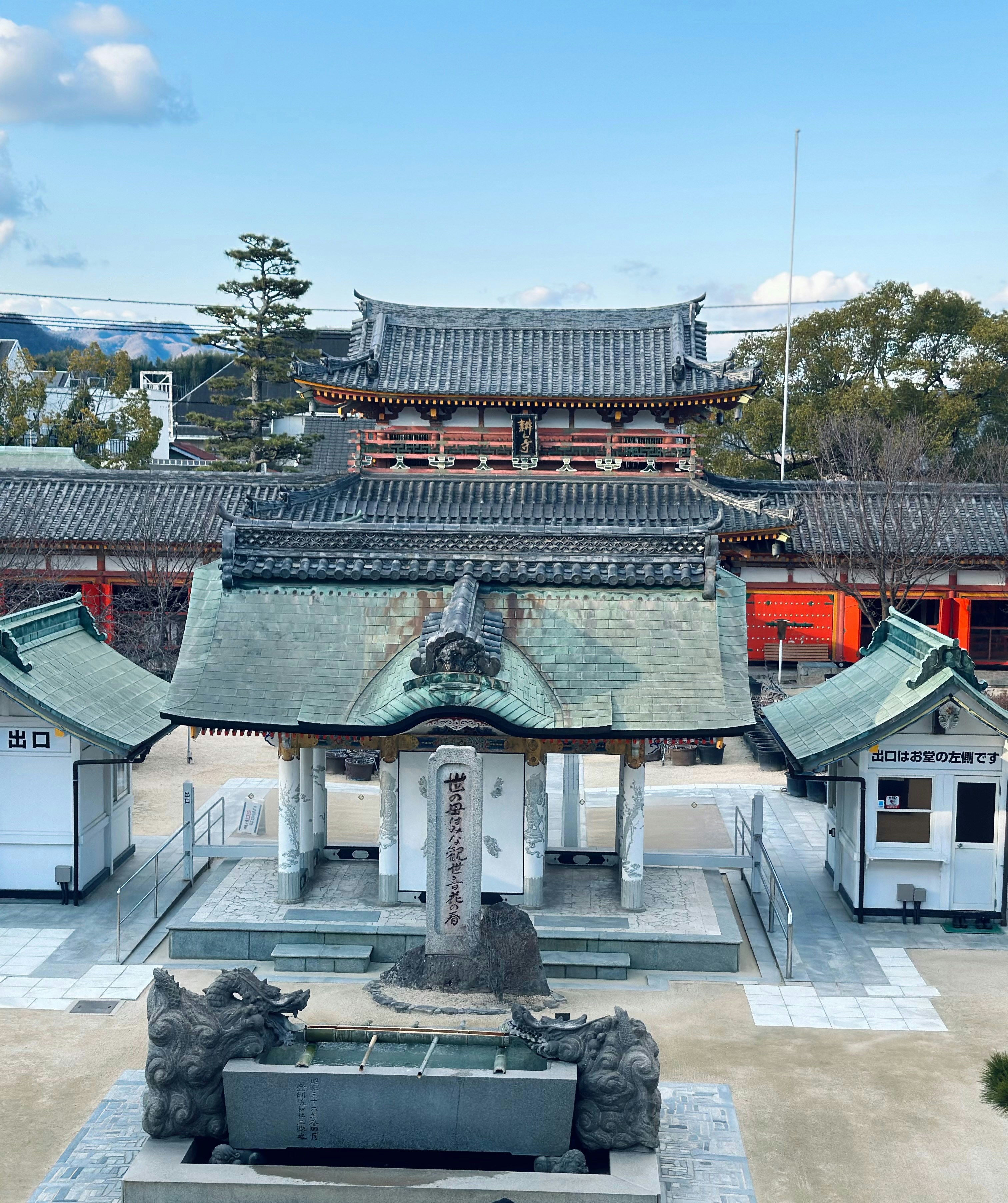 Courtyard of Quiet Echoes: A Temple Gate Framed by Curved Roofs and Dragon Fountain