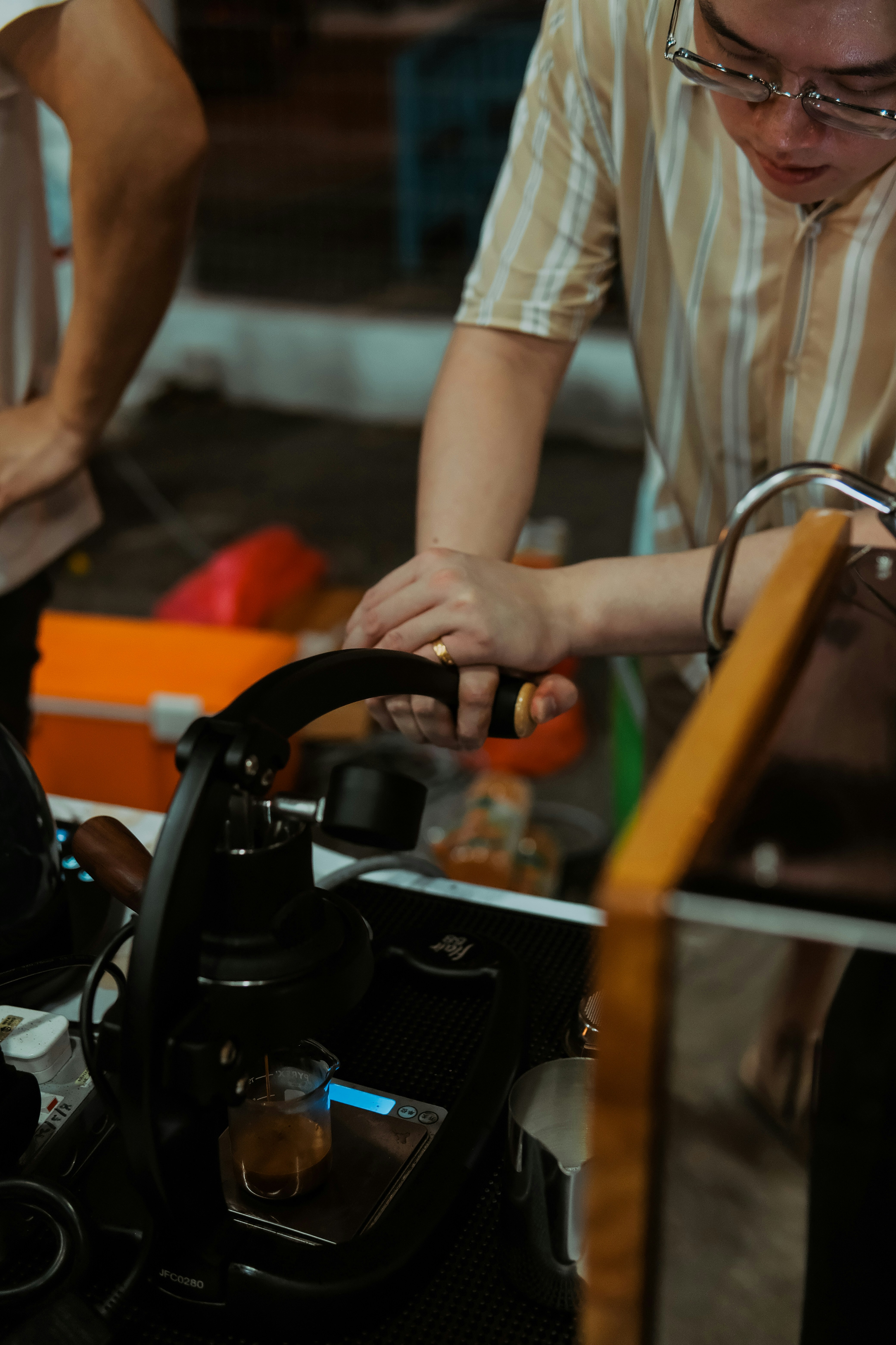 Close-up of a siphon-style coffee brewer at a busy prep station