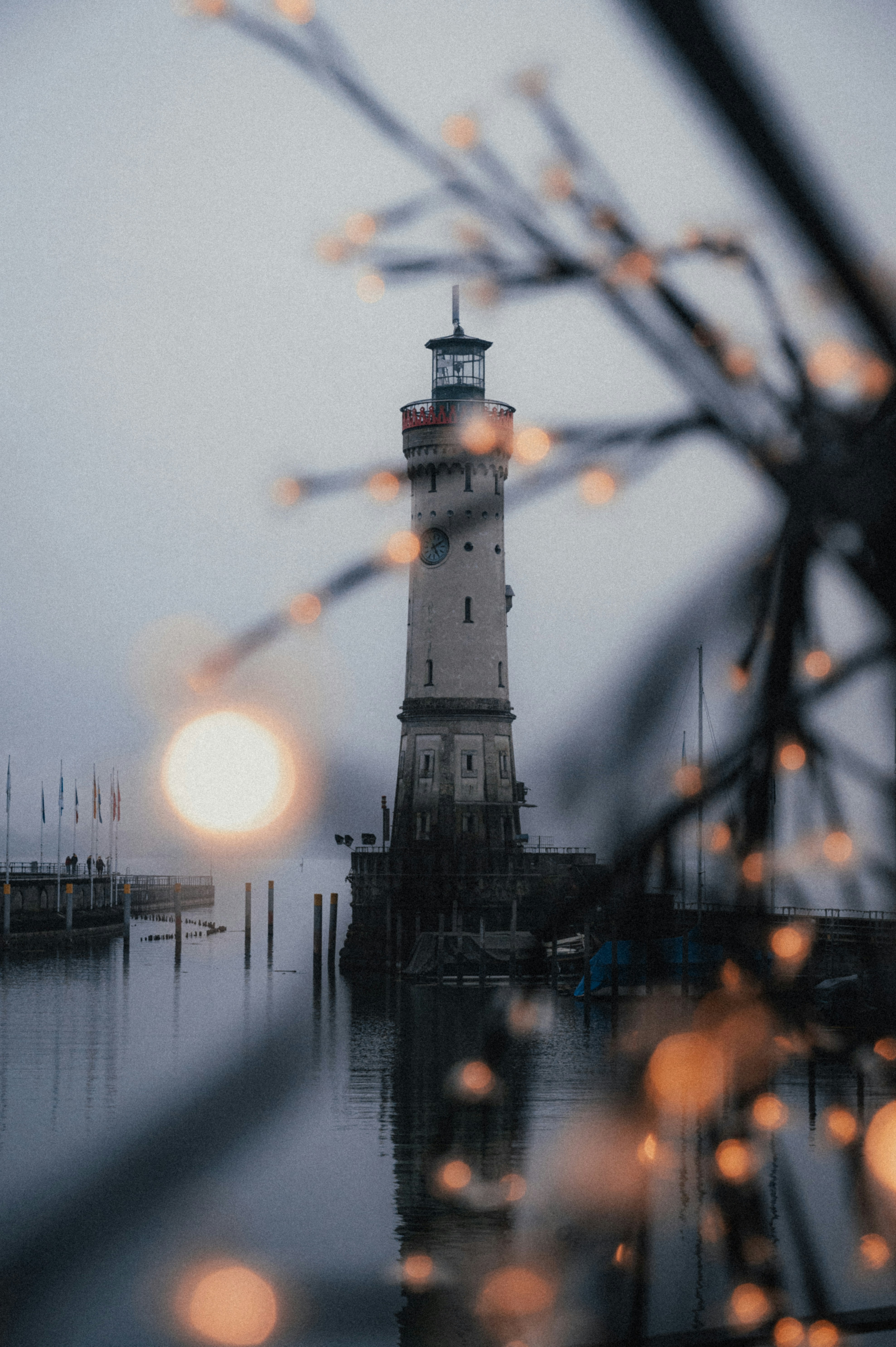 Beacon in the Mist: A Lighthouse Framed by Amber Orbs at Twilight