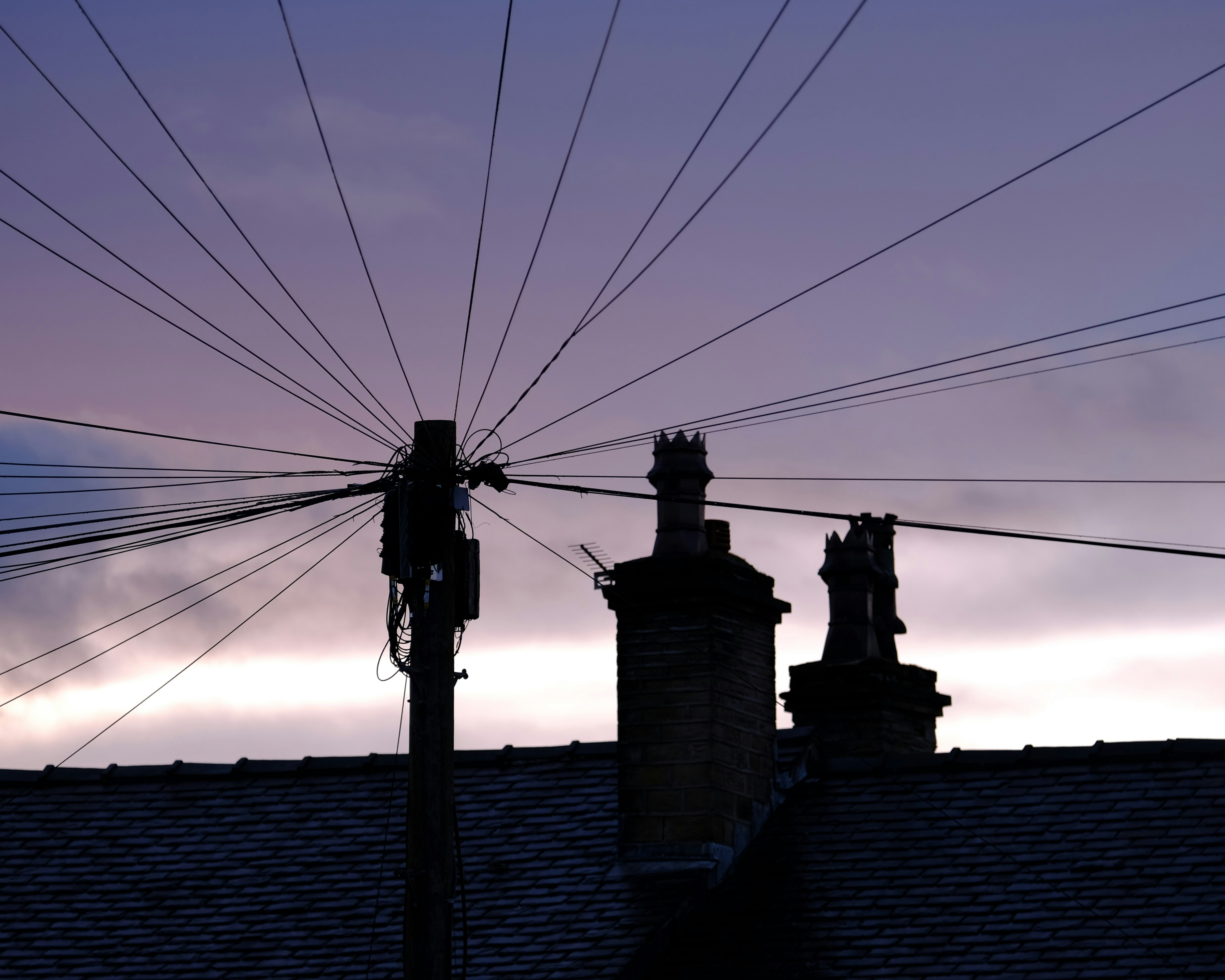 Dusk Convergence: Rooftop Silhouettes Framed by a Web of Wires