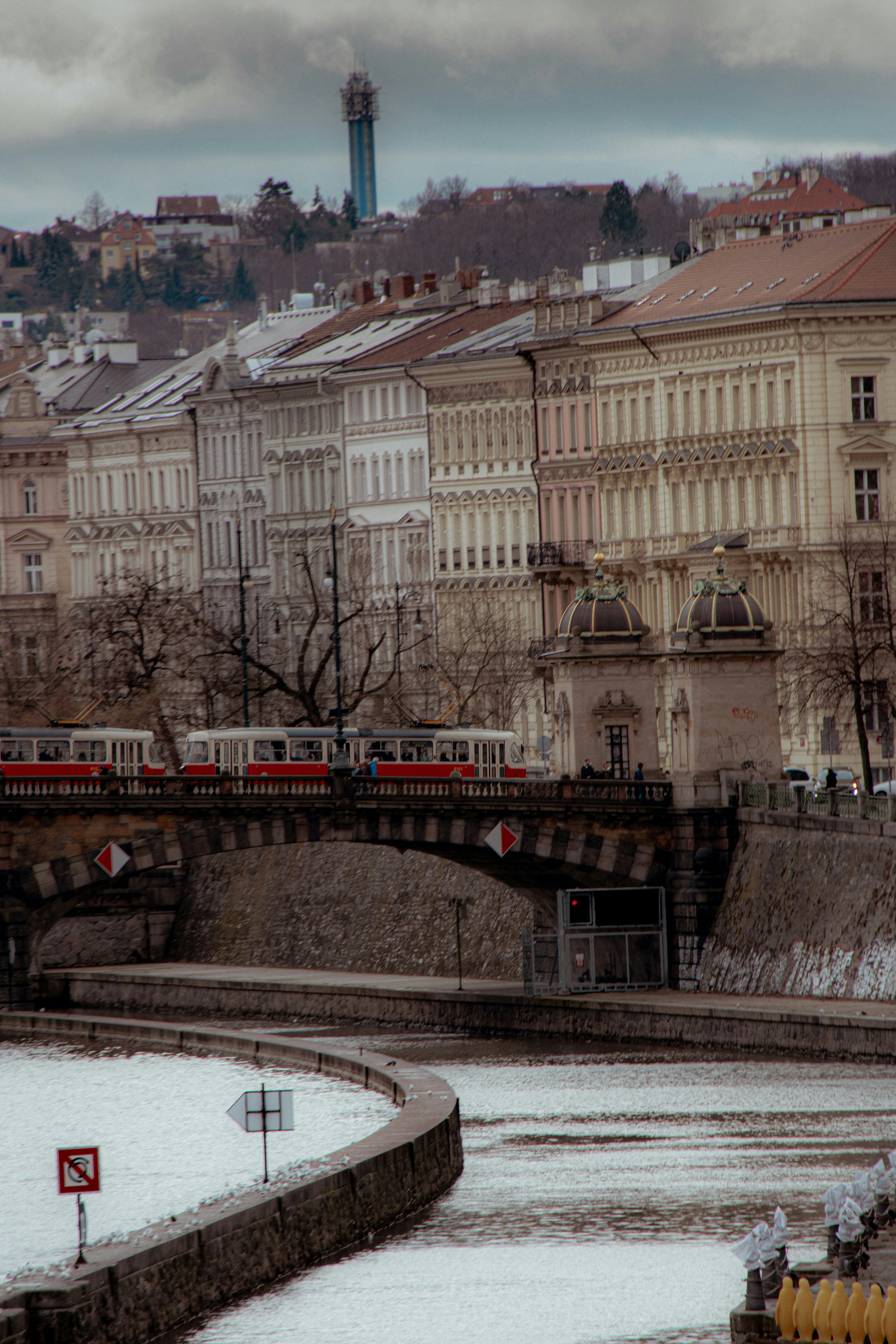 Riverside Facade Parade: Classic European Row Houses Along a Snowy Quay