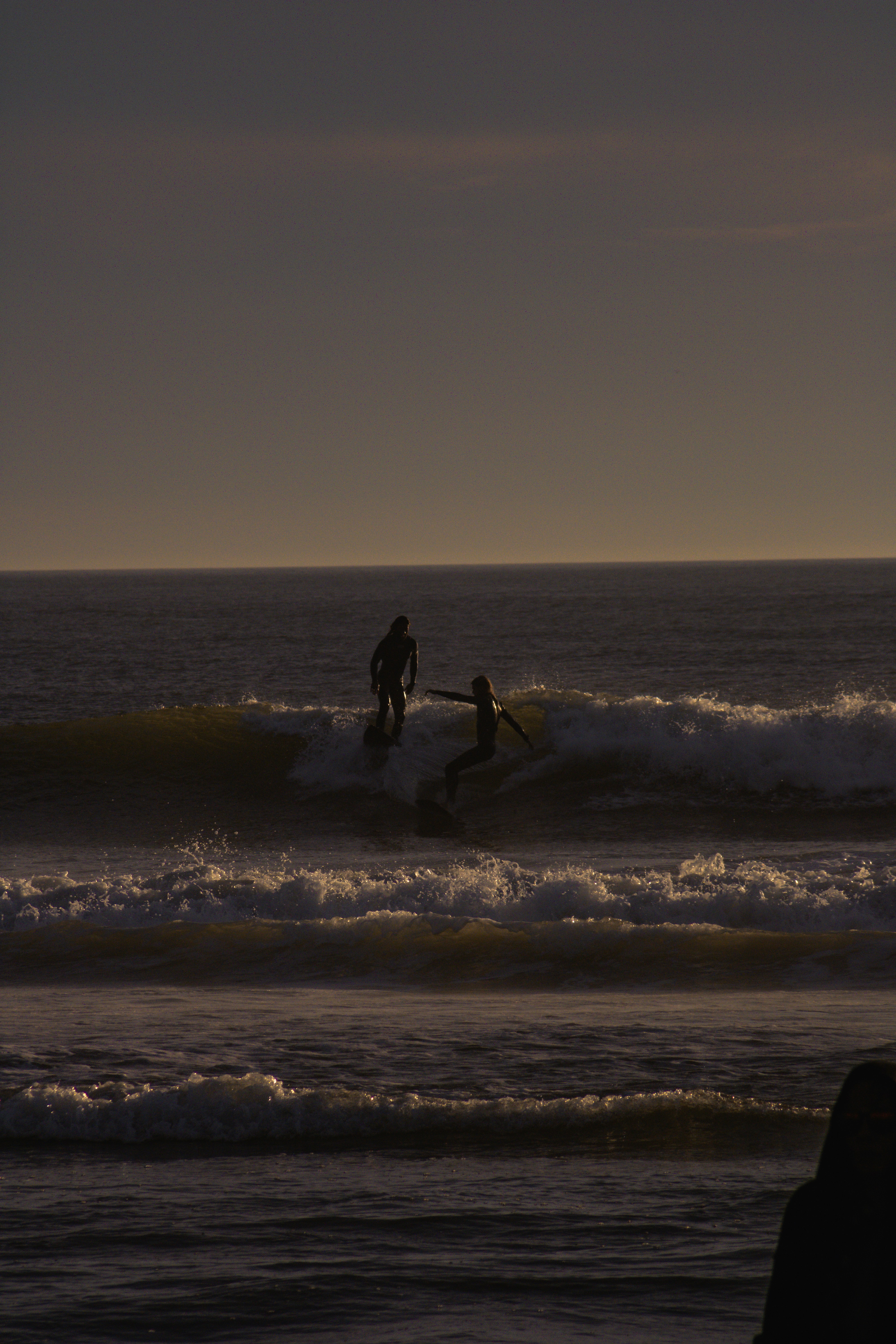 A couple of people riding waves on top of surfboards photo – Free Beach ...