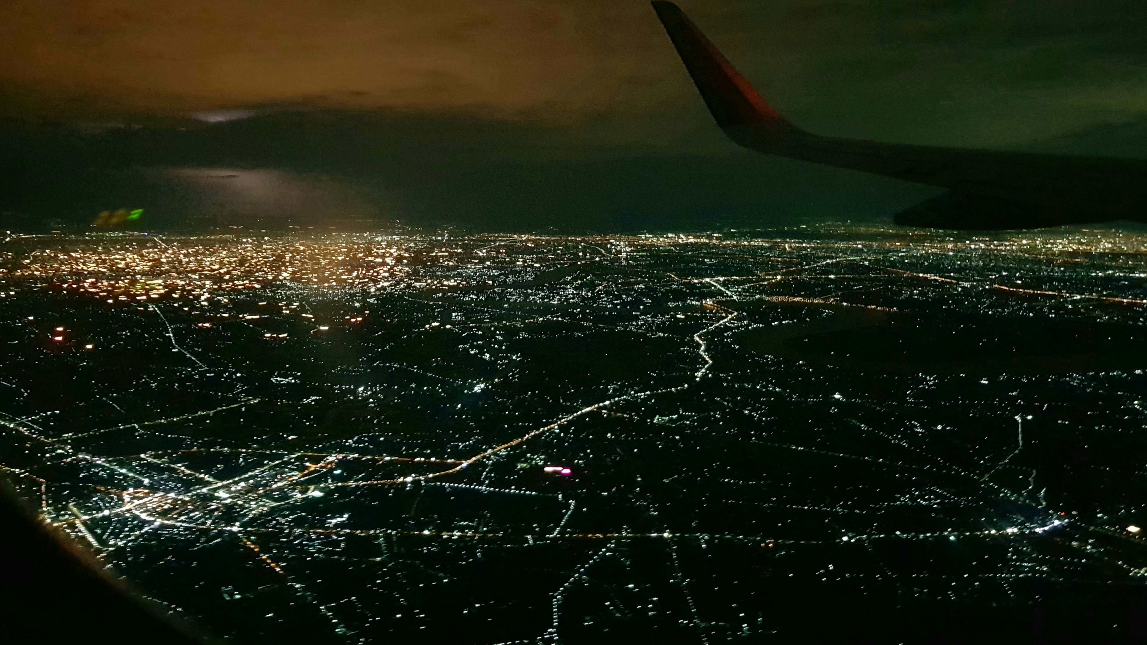 Wing Tip to Neon Grid: Night Flight Over a City of Lights