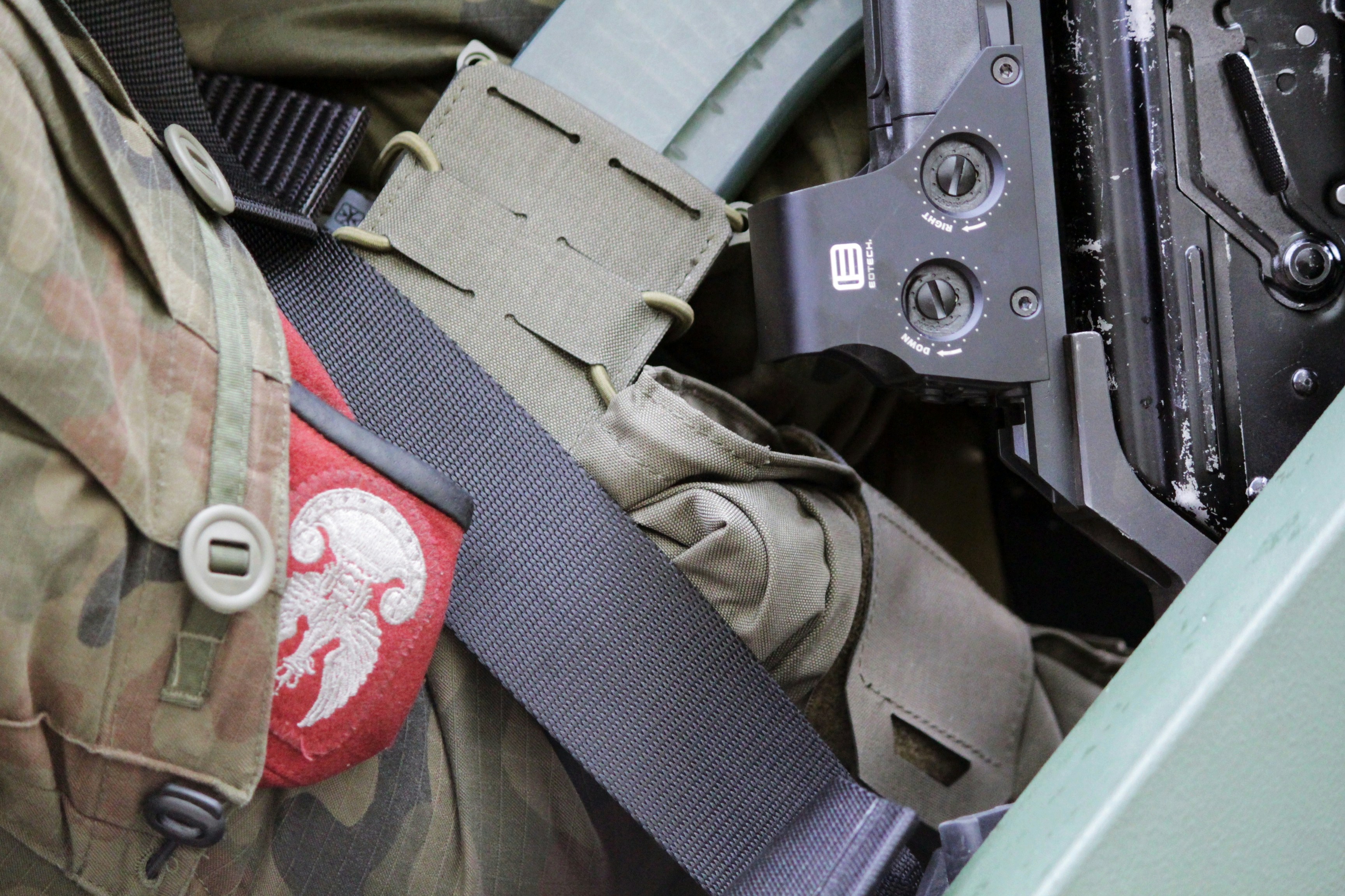 Close-up of a soldier's uniform, showcasing a patch and the secure fastening of a seatbelt in a military vehicle.