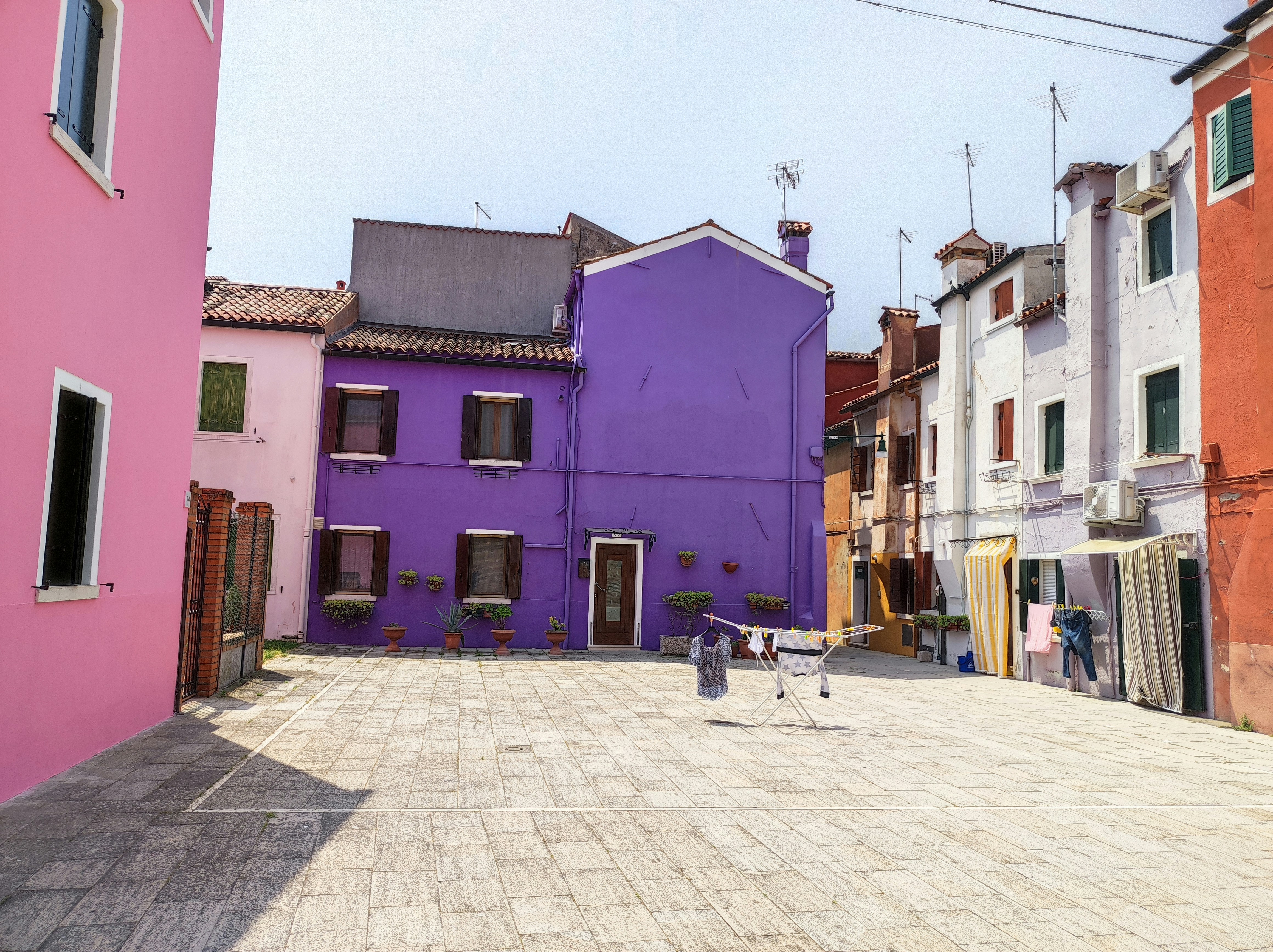 Sunlit Courtyard of Rainbow Facades: A Quiet Piazza Between Colorful Homes