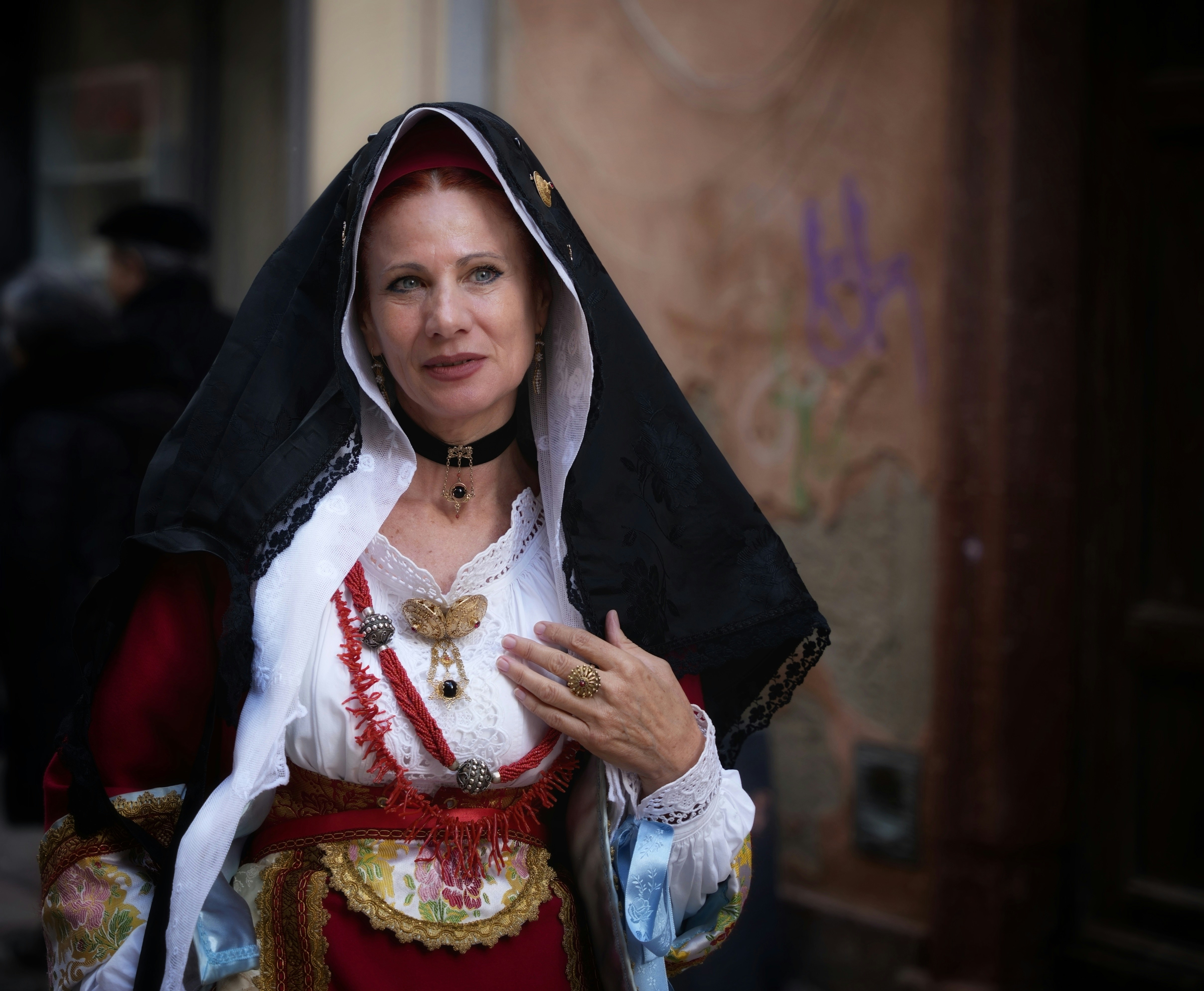 Woman in traditional attire adorned with intricate jewelry and a striking headpiece, exuding cultural heritage and grace.