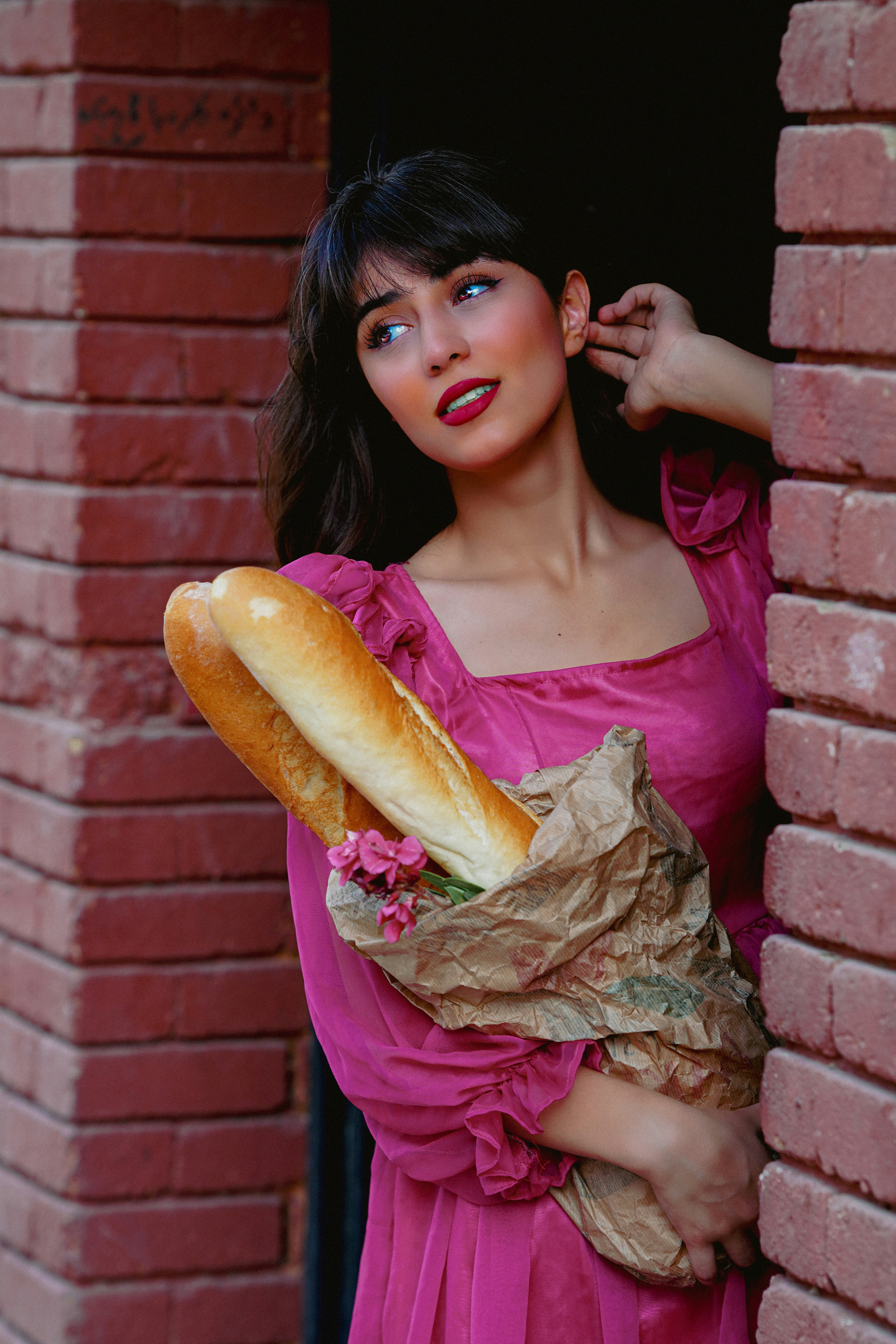 A woman in a pink dress holding a loaf of bread photo – Free Food Image ...