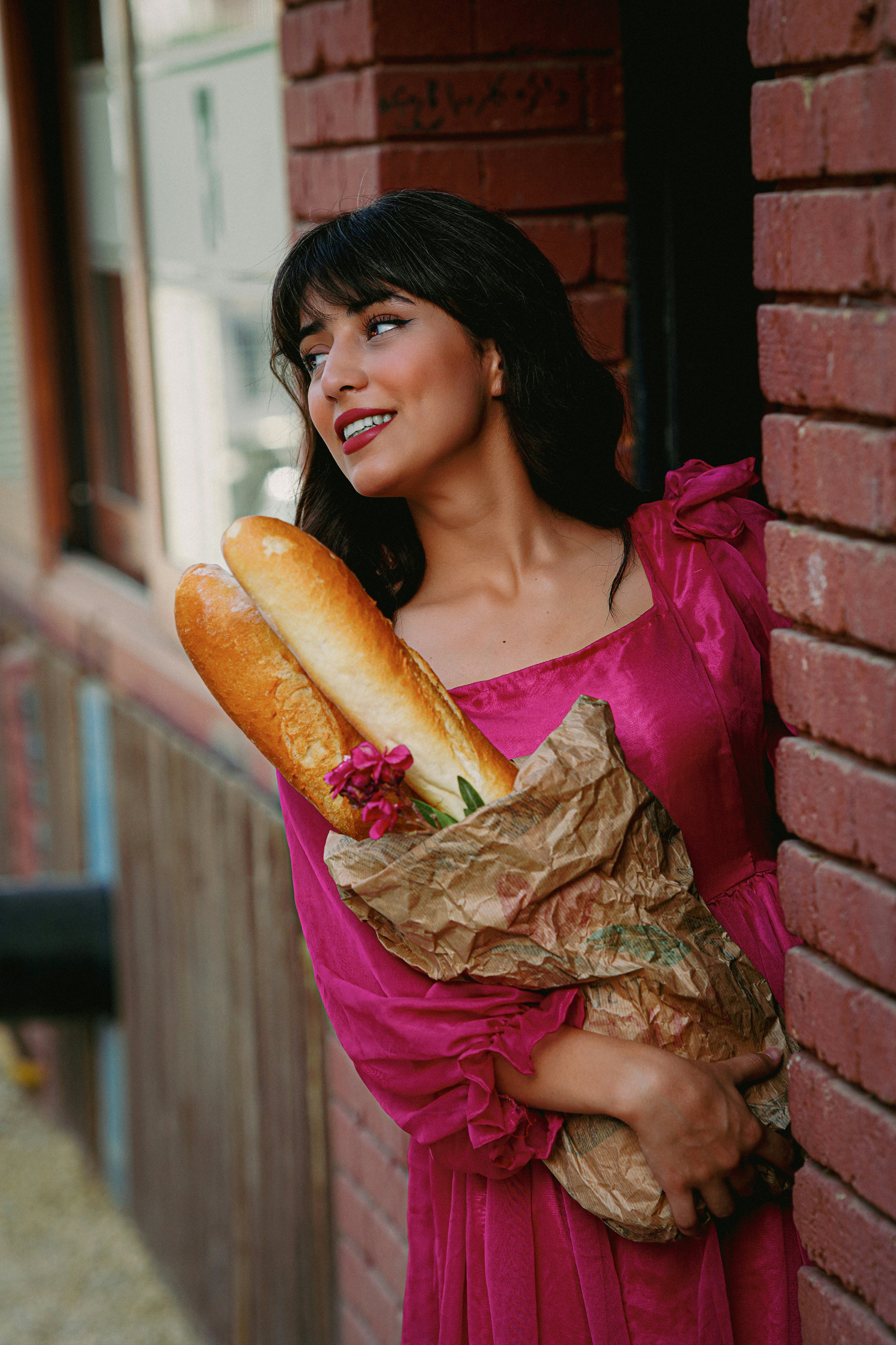 A woman in a pink dress holding a loaf of bread photo – Free Bread ...