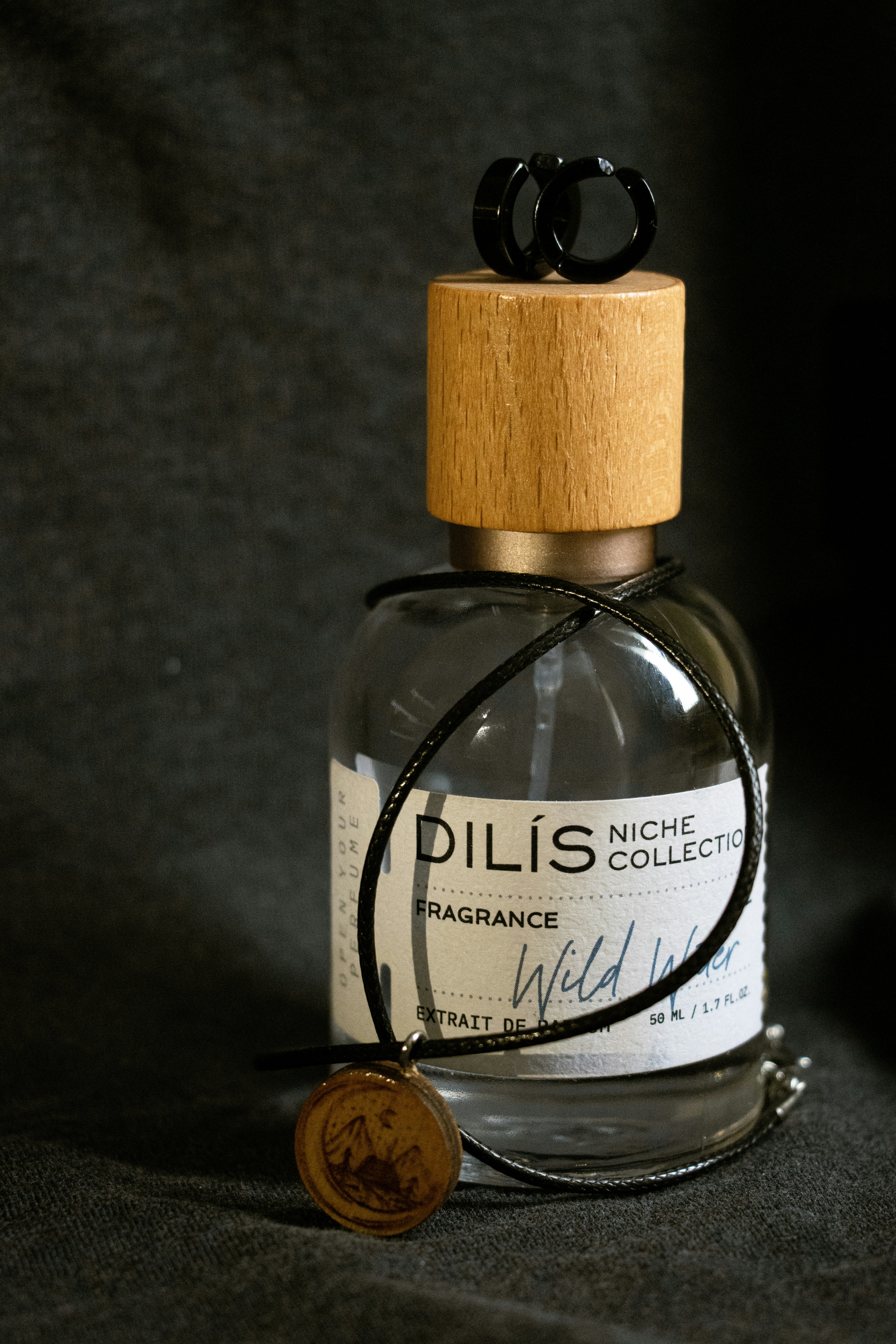 Two Black Rings Crown a Fragrance Bottle: A Quiet Still-Life Portrait