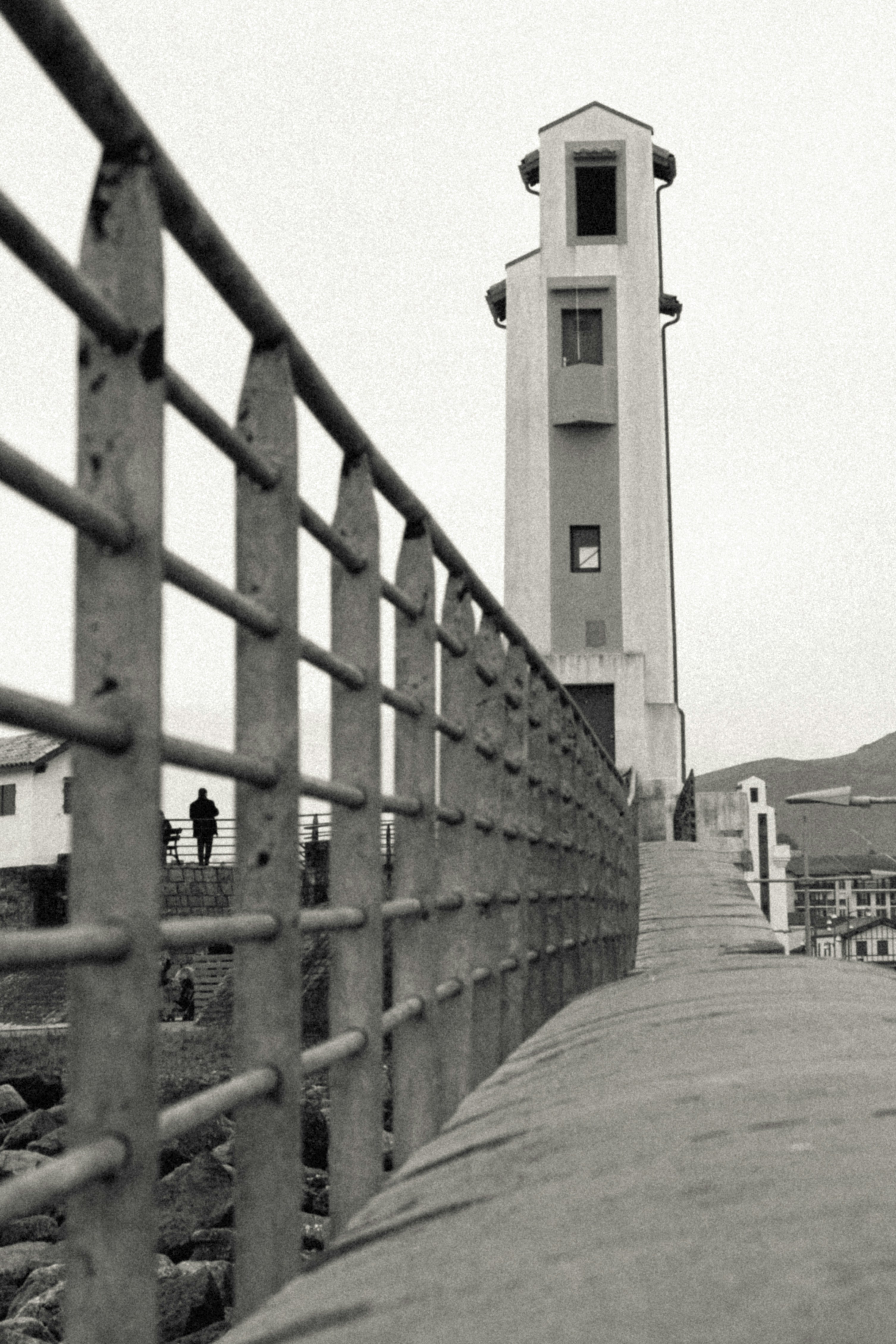 Towering Beams and Rail Lines: A Quiet Promenade Toward the Lighthouse