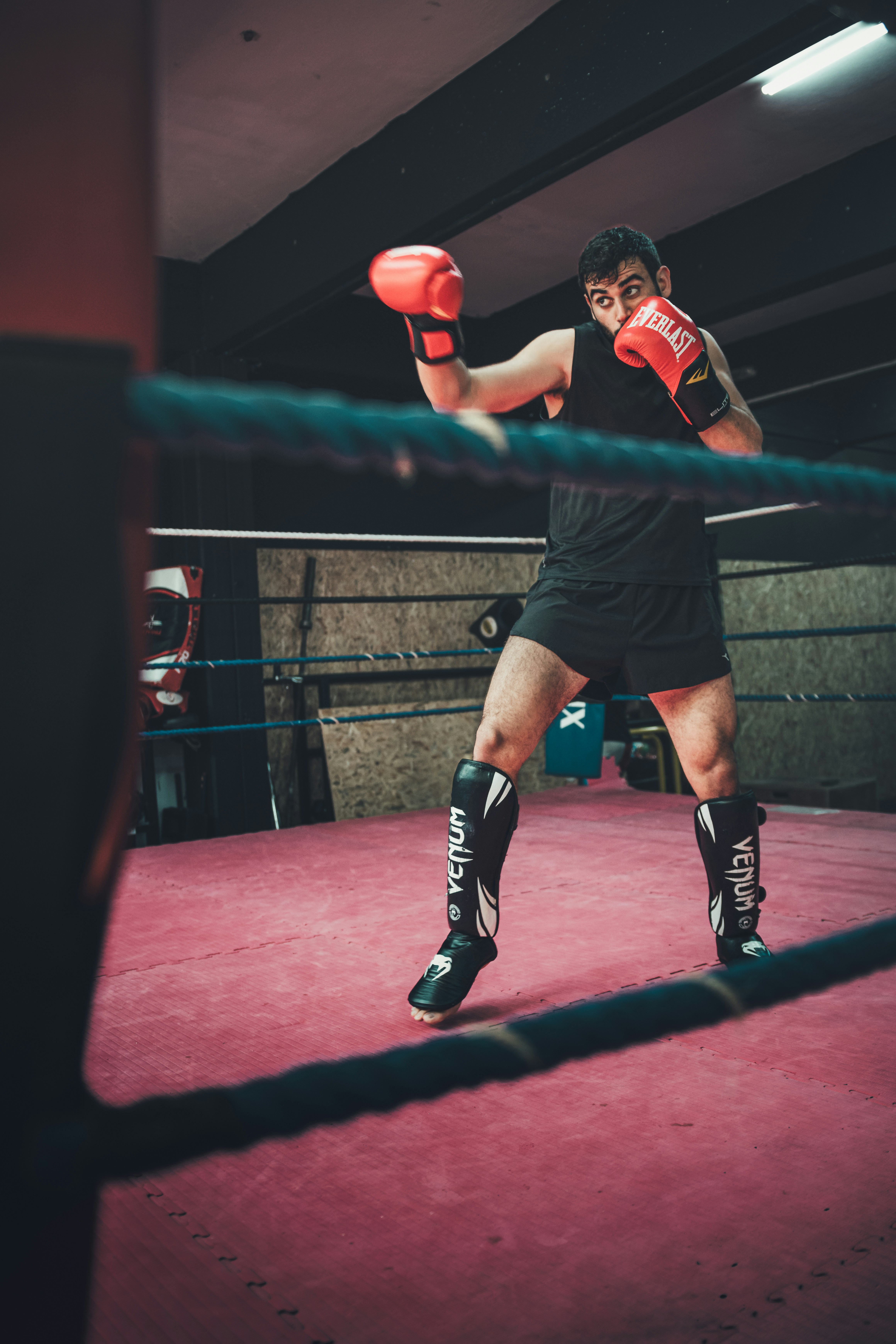 A man standing in a boxing ring holding a red boxing glove photo – Free ...