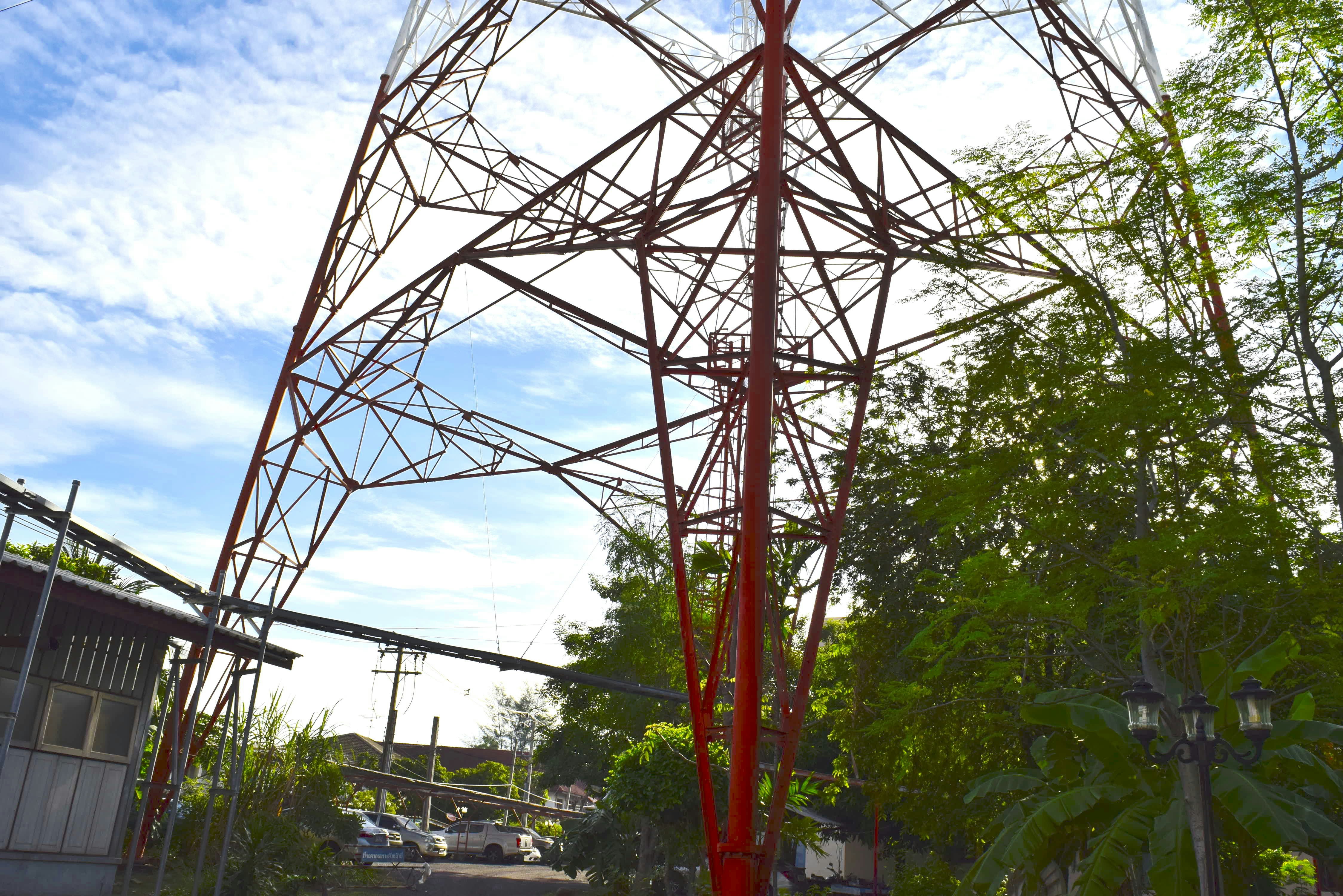 Crimson Trusswork Reaches the Sky Over a Quiet Urban Park