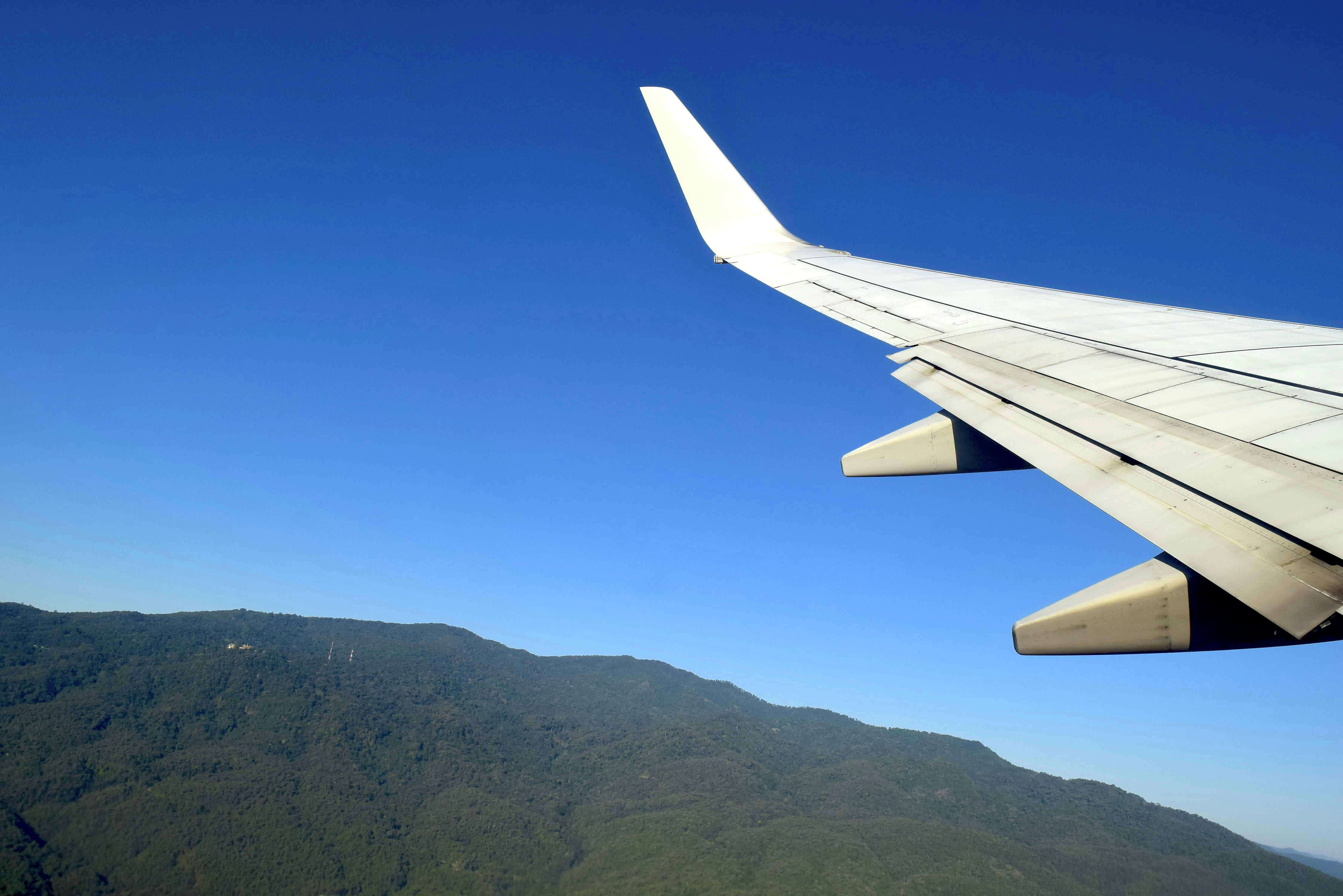 L’aile d’un avion survolant une chaîne de montagnes photo – Photo ...