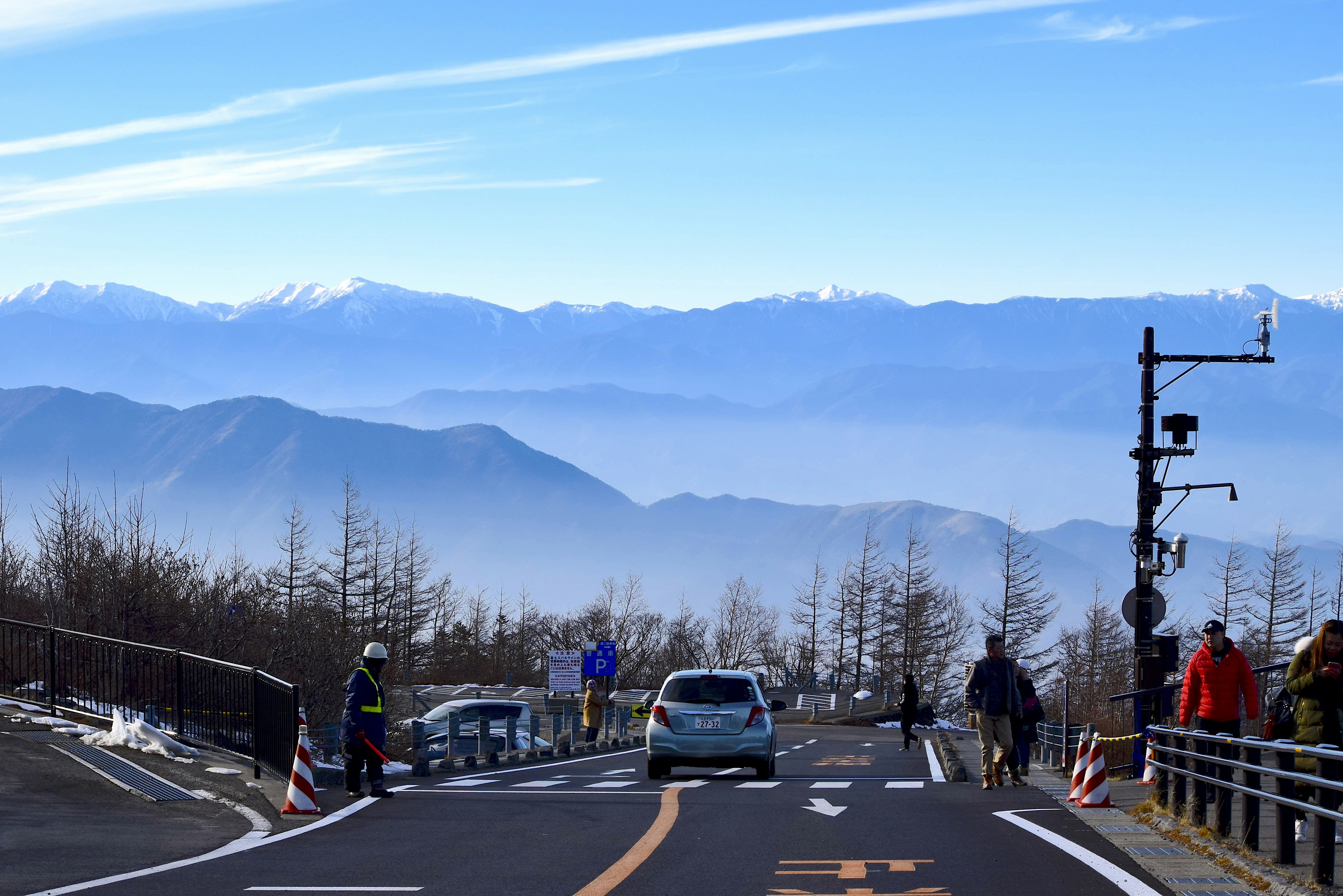 The way to destination. | a group of people standing on the side of a road